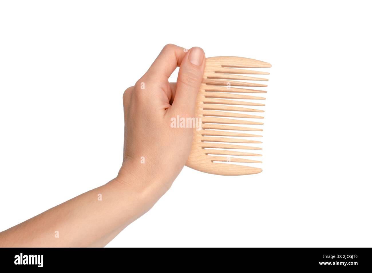 Wooden hair comb in a female hand on a white background Stock Photo - Alamy