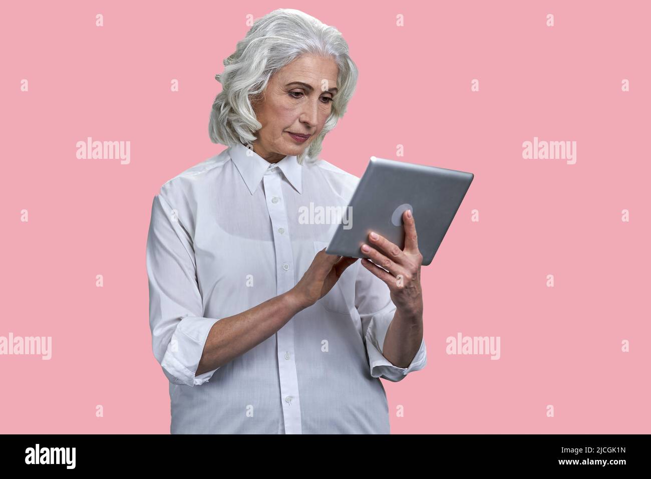 Confident senior business lady reading news on digital tablet. Mature ...