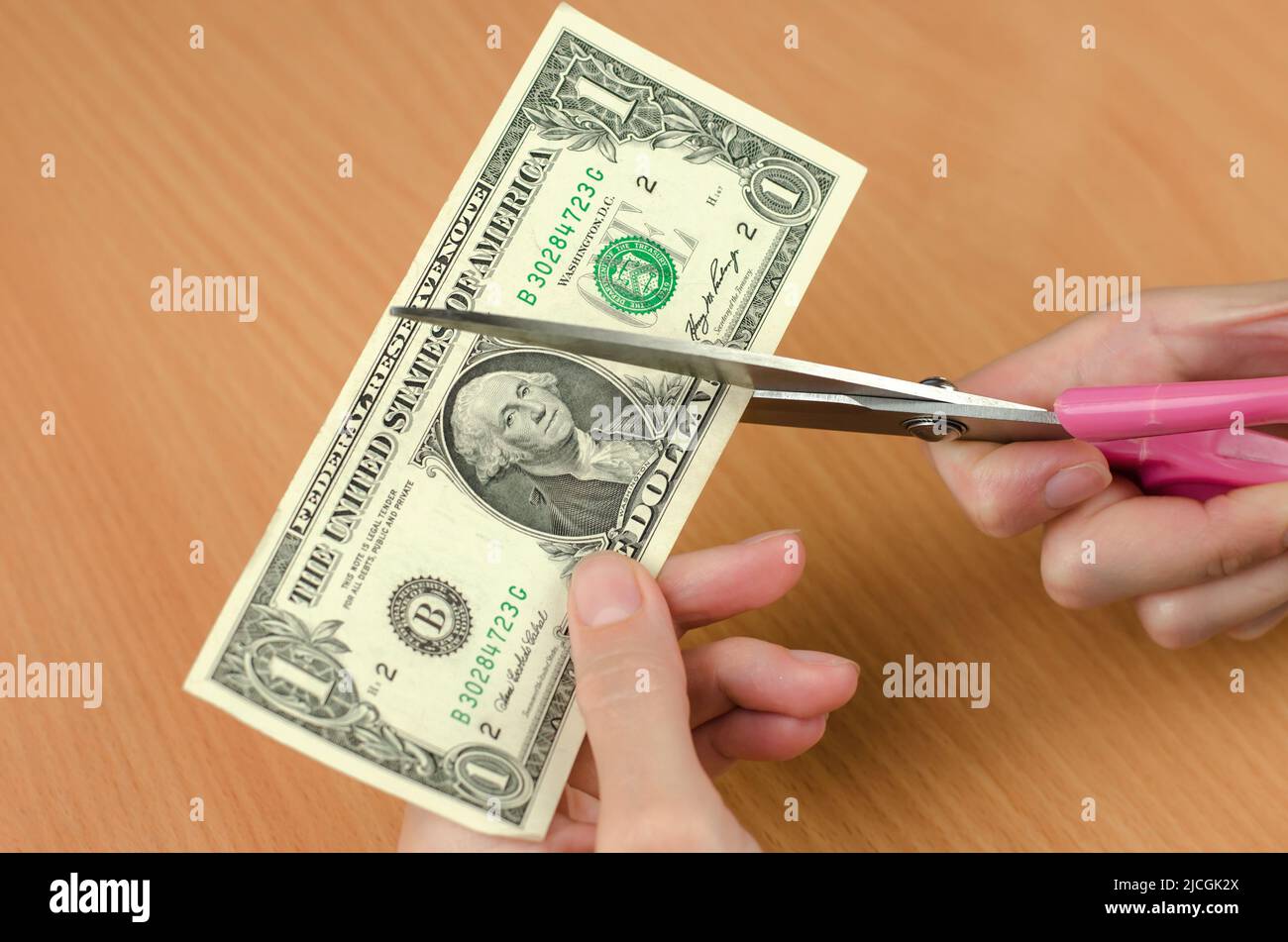 Close-up of female hands cutting one dollar bill with scissors Stock ...