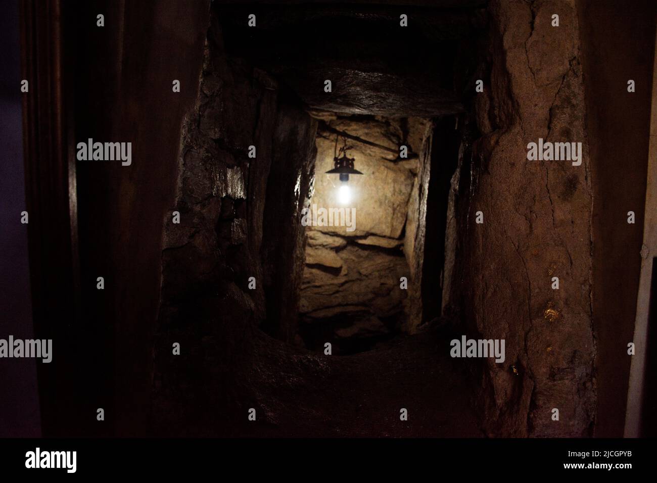 Tunnel gate entrance to mining cave to underground with warm white ...
