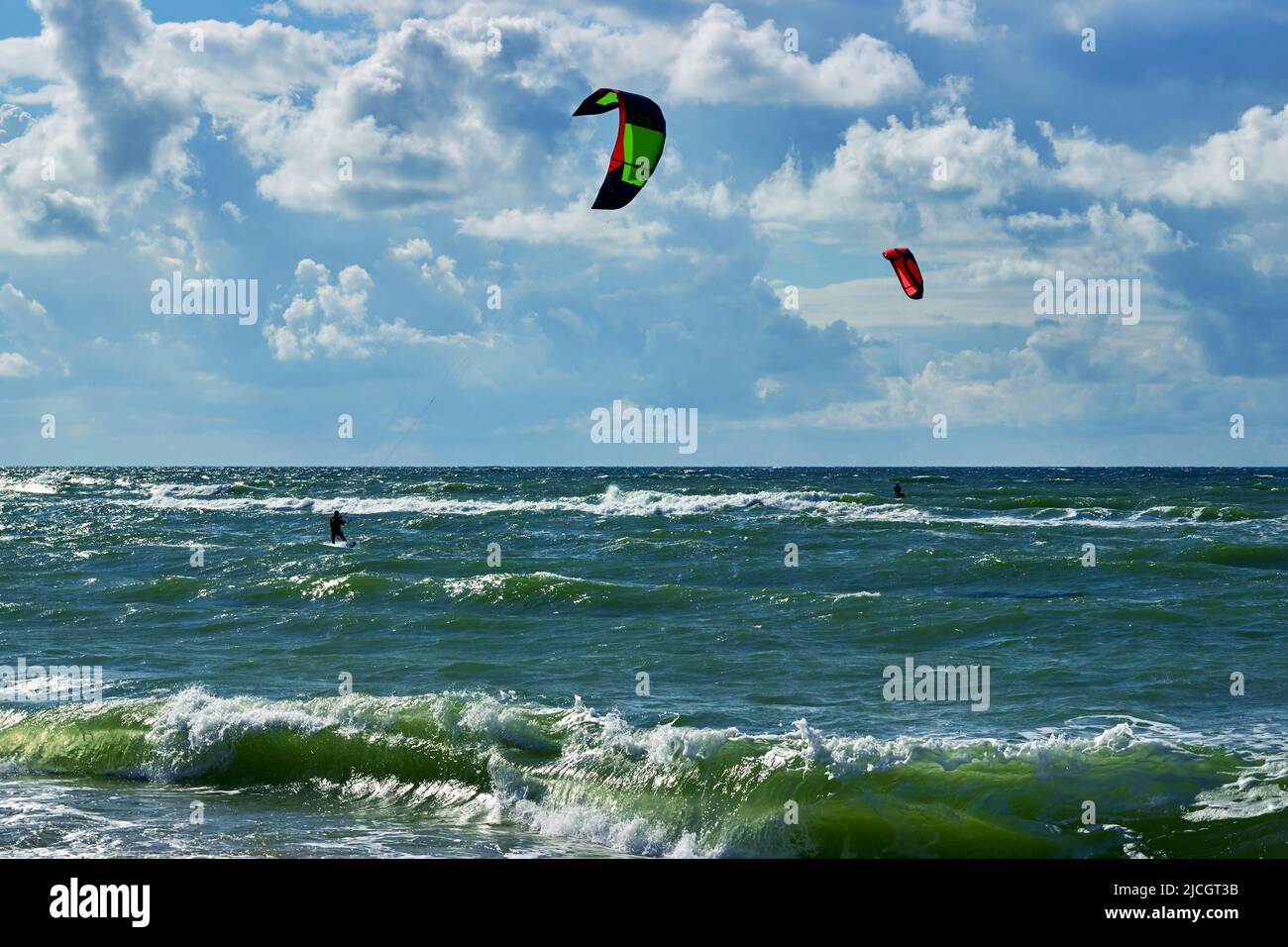 Two kite surfers glide on the sea in sunny windy weather. Beautiful ...