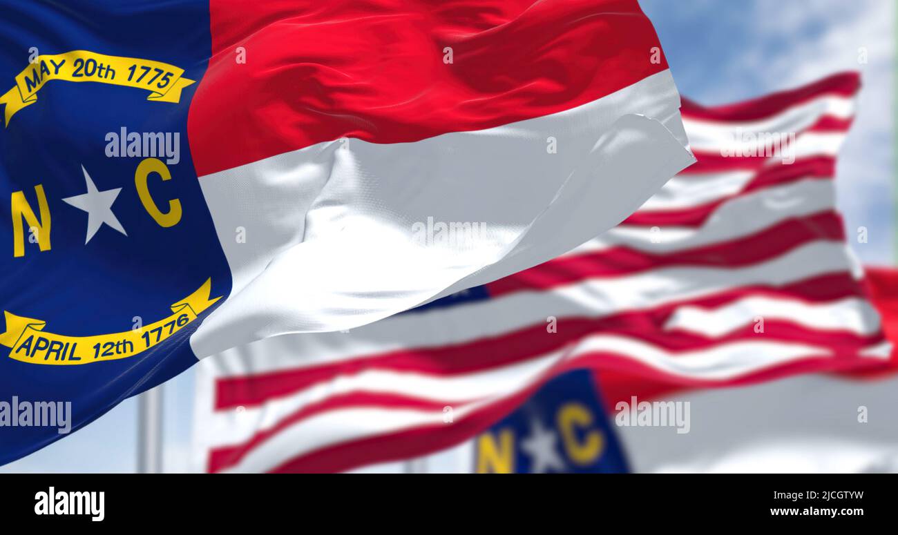 The North Carolina state flag waving along with the national flag of ...