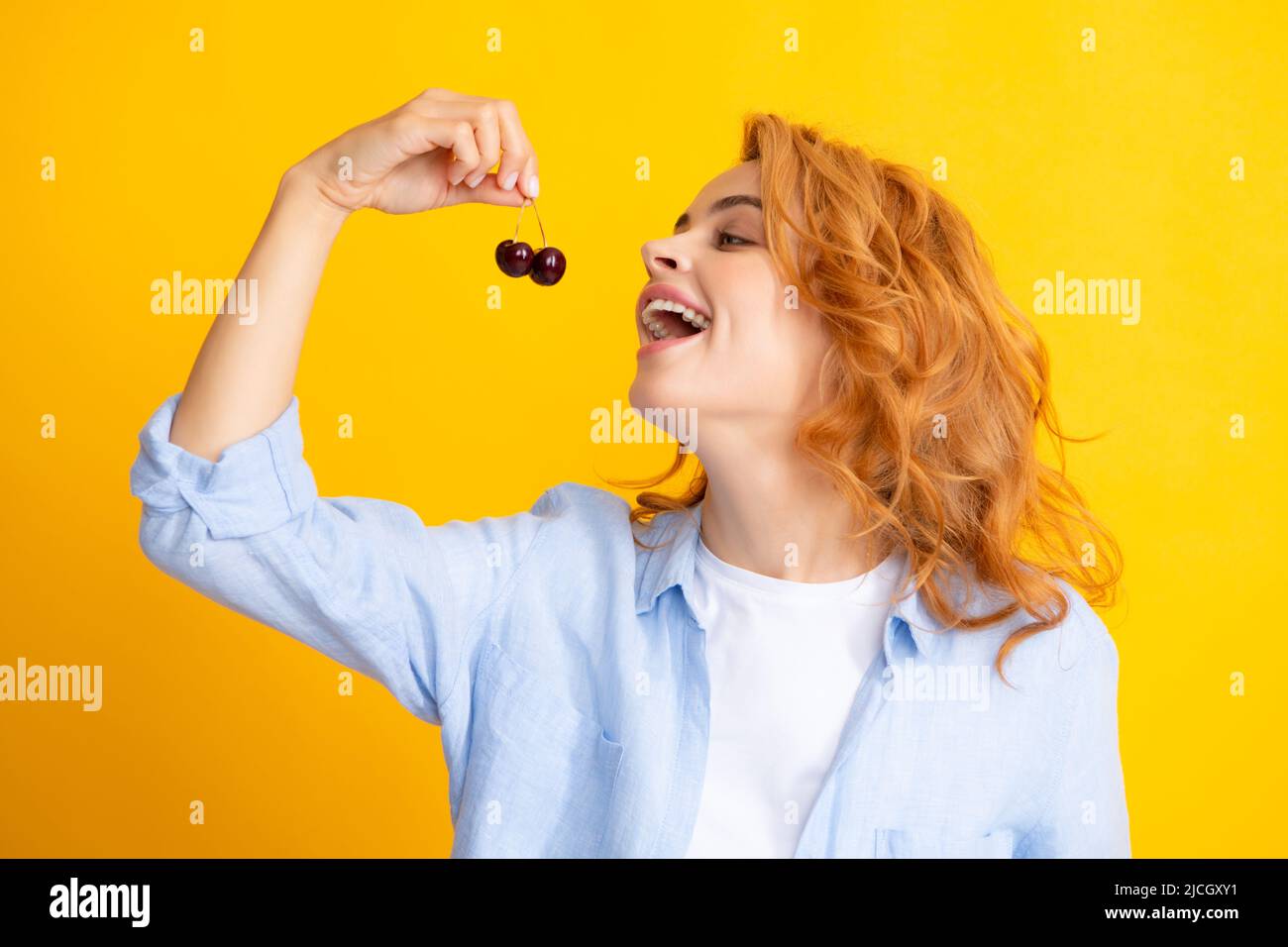 Attractive young woman eating fresh cherry. Healthy summer fruits ...