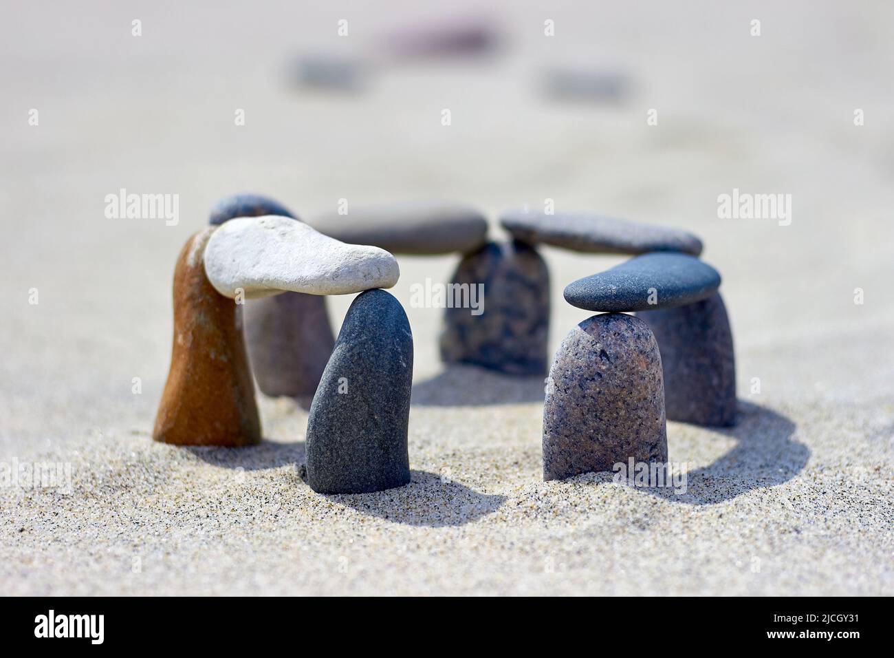 Balanced pebbles on the sandy coast. Stones are stacked on the beach ...