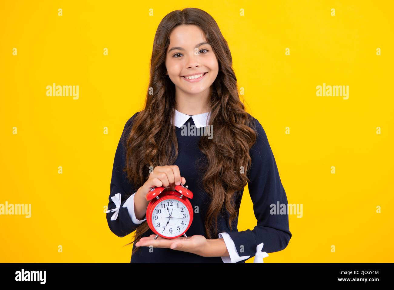 Punctual teen girl checking time. Child with alarm clock showing time ...