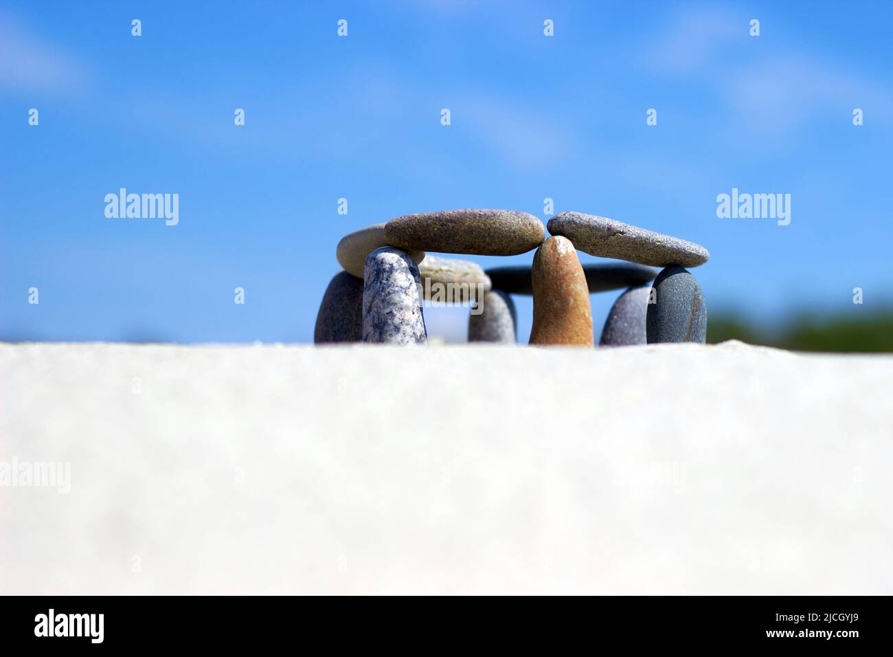 Balanced pebbles on the sandy coast. Stones are stacked on the beach ...