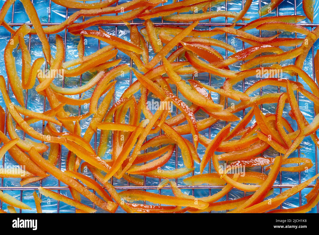 Candied orange peel on a wire rack on a blue background Stock Photo - Alamy
