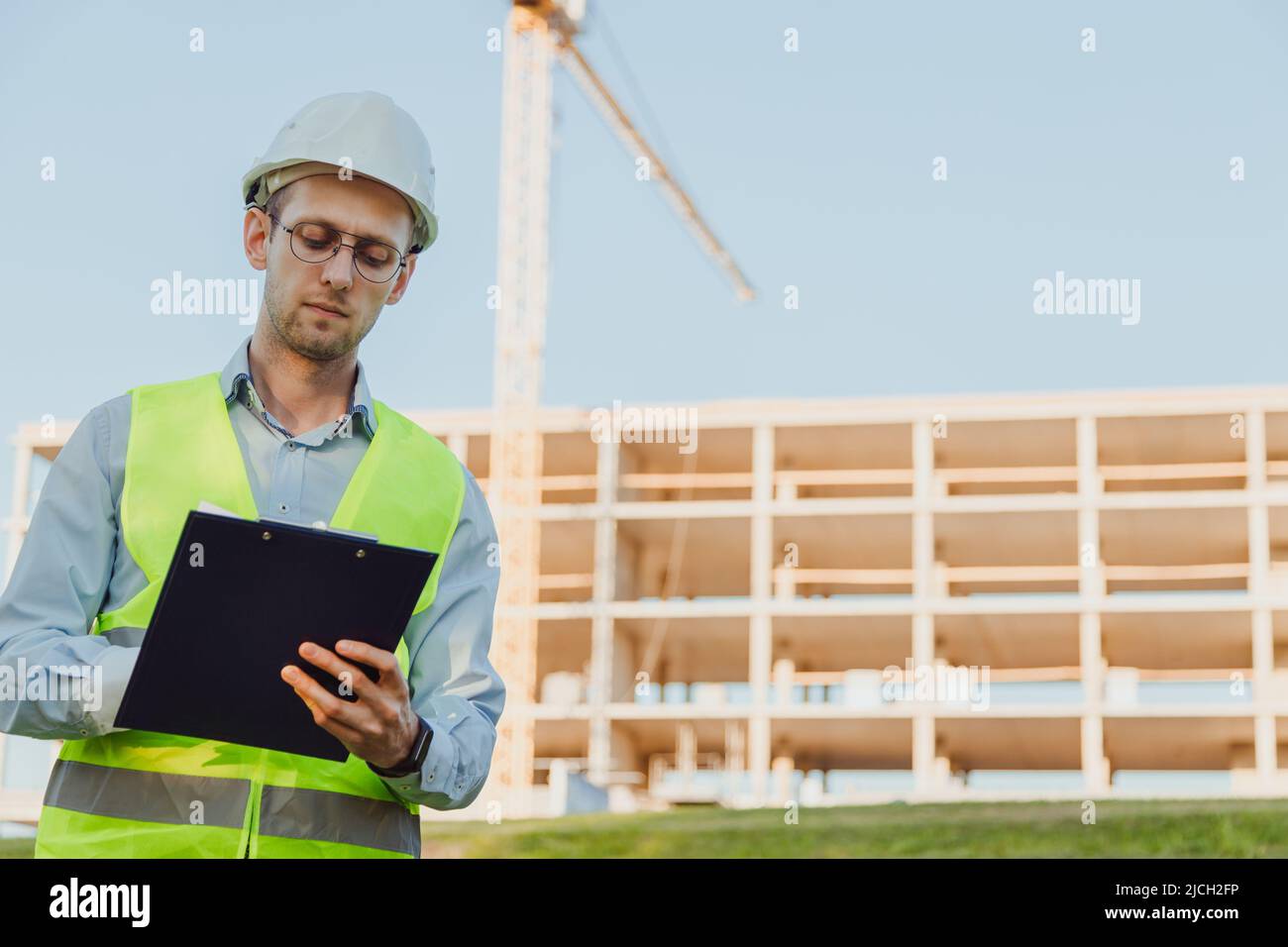 Engineer builder in white hat with folder at construction site Stock ...