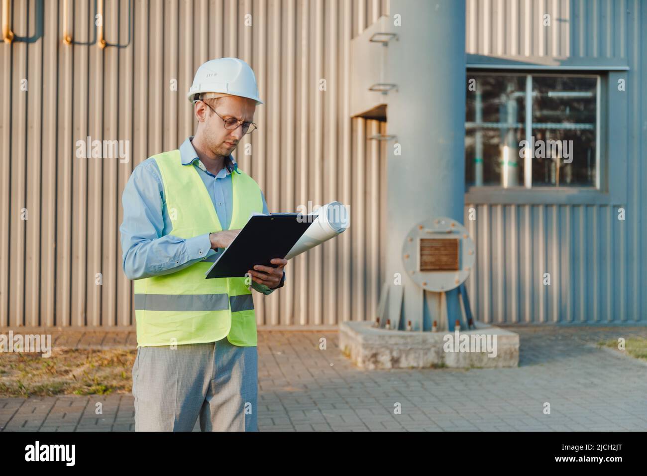 Foreman supervisor in suit and helmet on head, holding folder with ...
