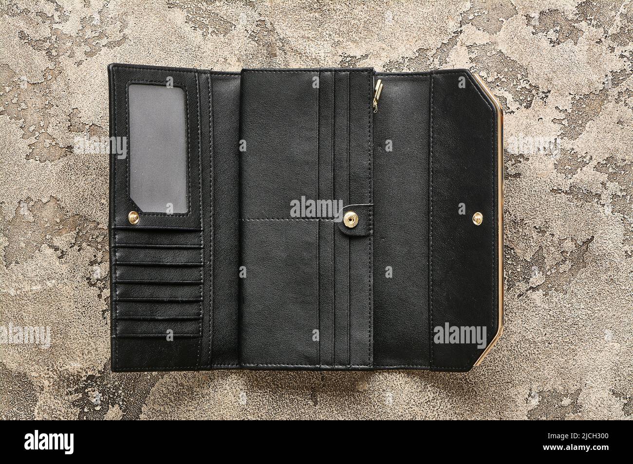 an open black female empty purse lies on a gray concrete background ...