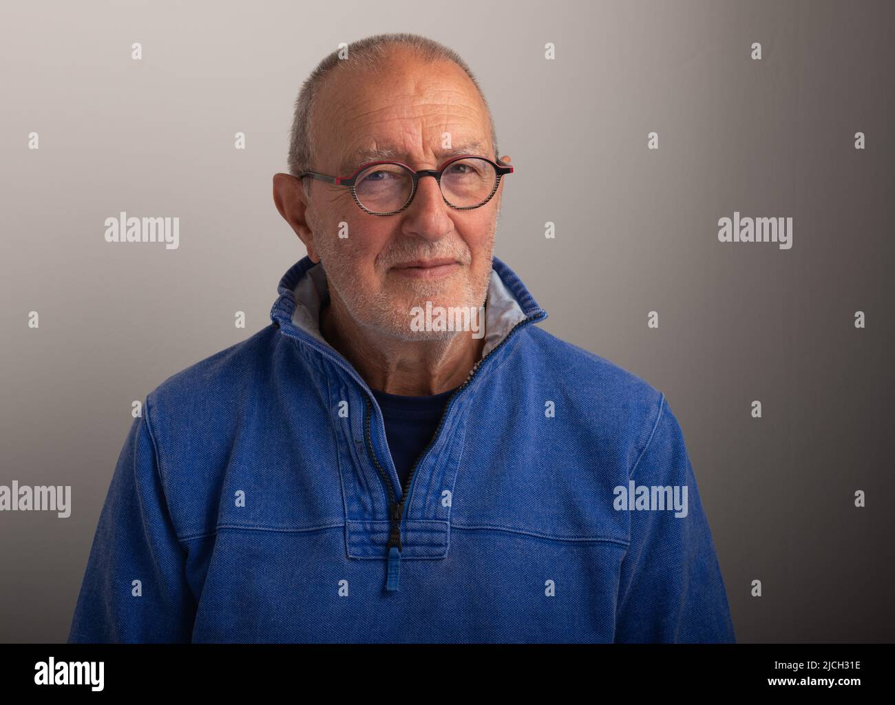 Senior man wearing glasses on a plain background Stock Photo - Alamy