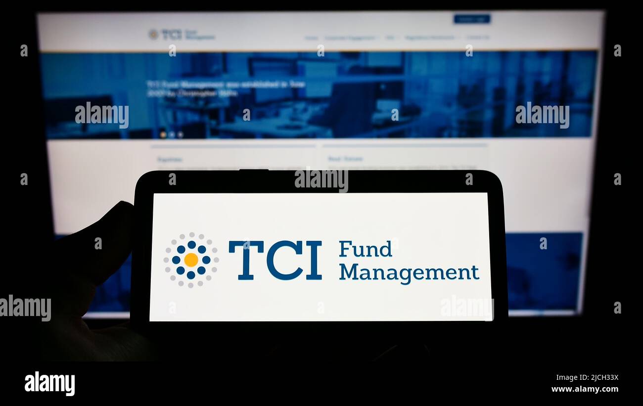 Person holding smartphone with logo of hedge fund company TCI Fund ...