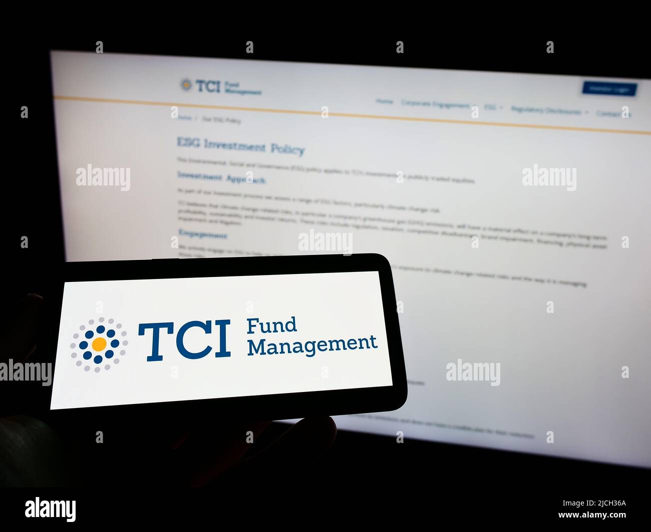 Person holding mobile phone with logo of hedge fund company TCI Fund ...