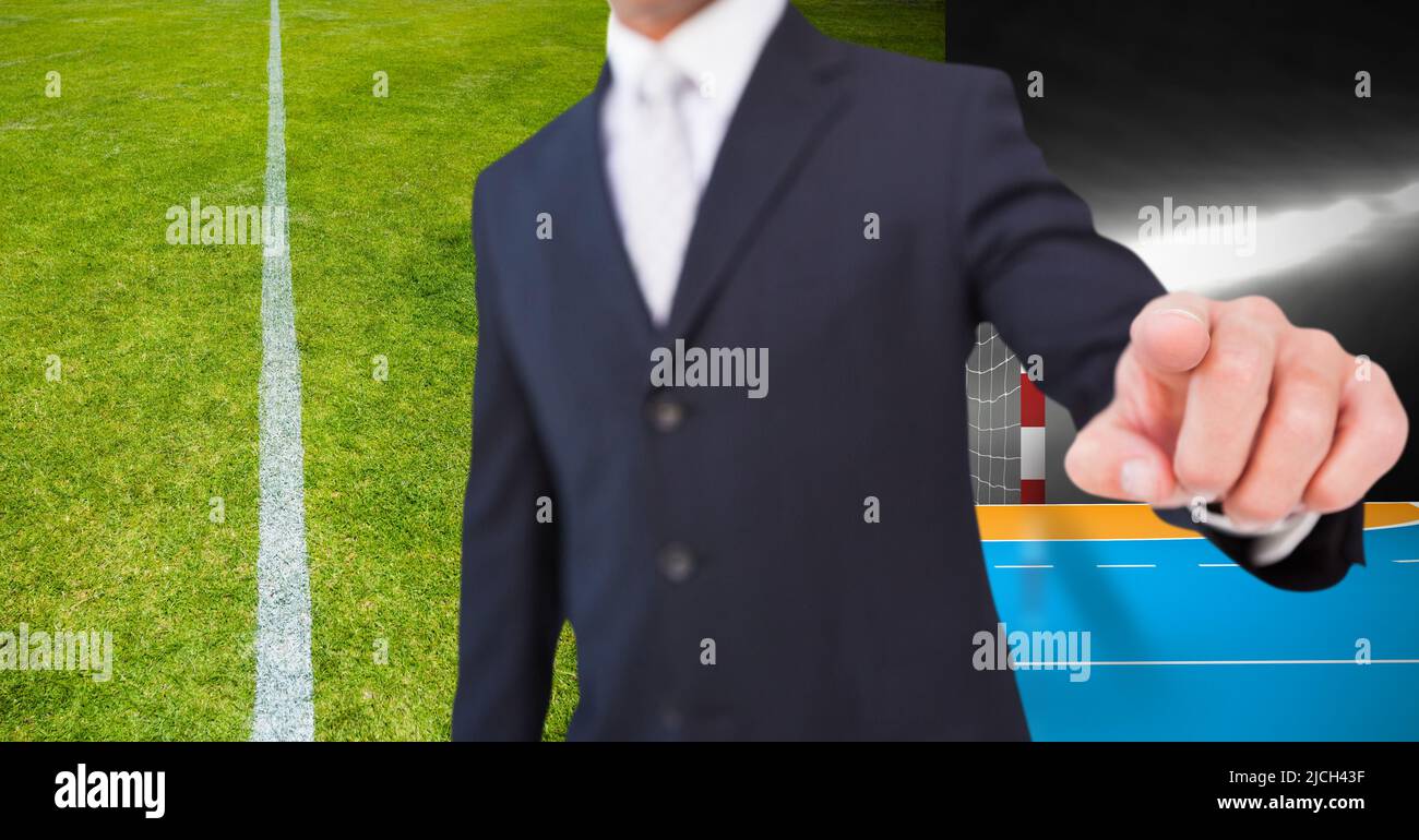 Mid section of businessman touching an invisible screen against sports ...
