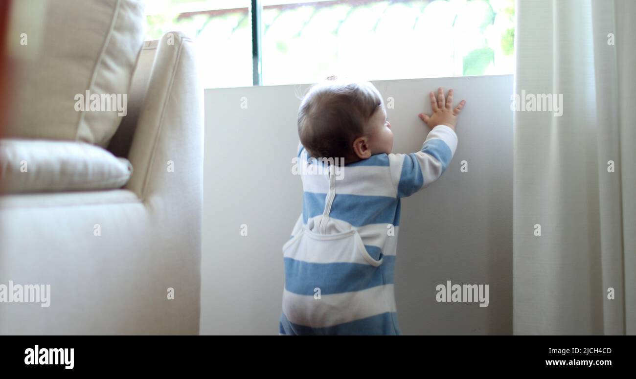 Cute baby boy standing up at home. Infant child learning development ...