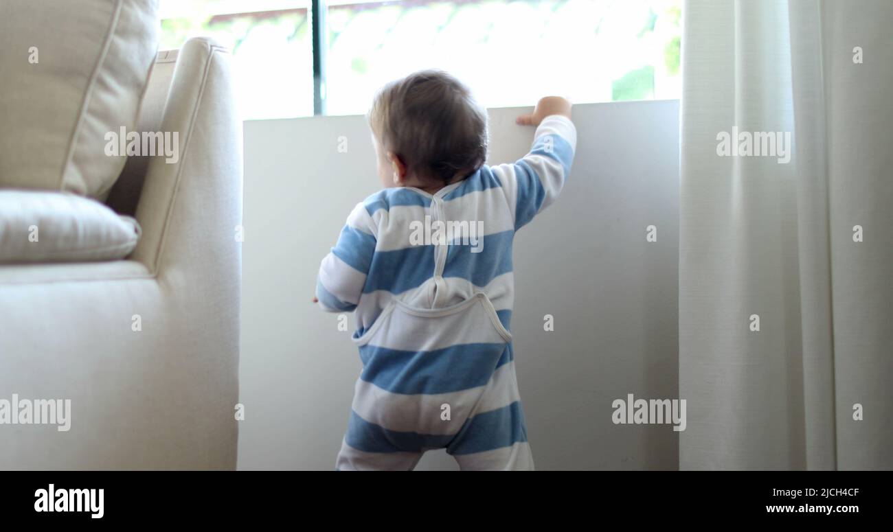 Cute baby boy standing up at home. Infant child learning development ...