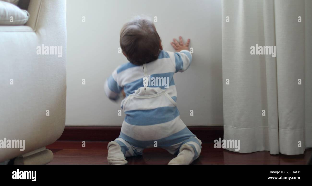 Cute baby boy standing up at home. Infant child learning development ...