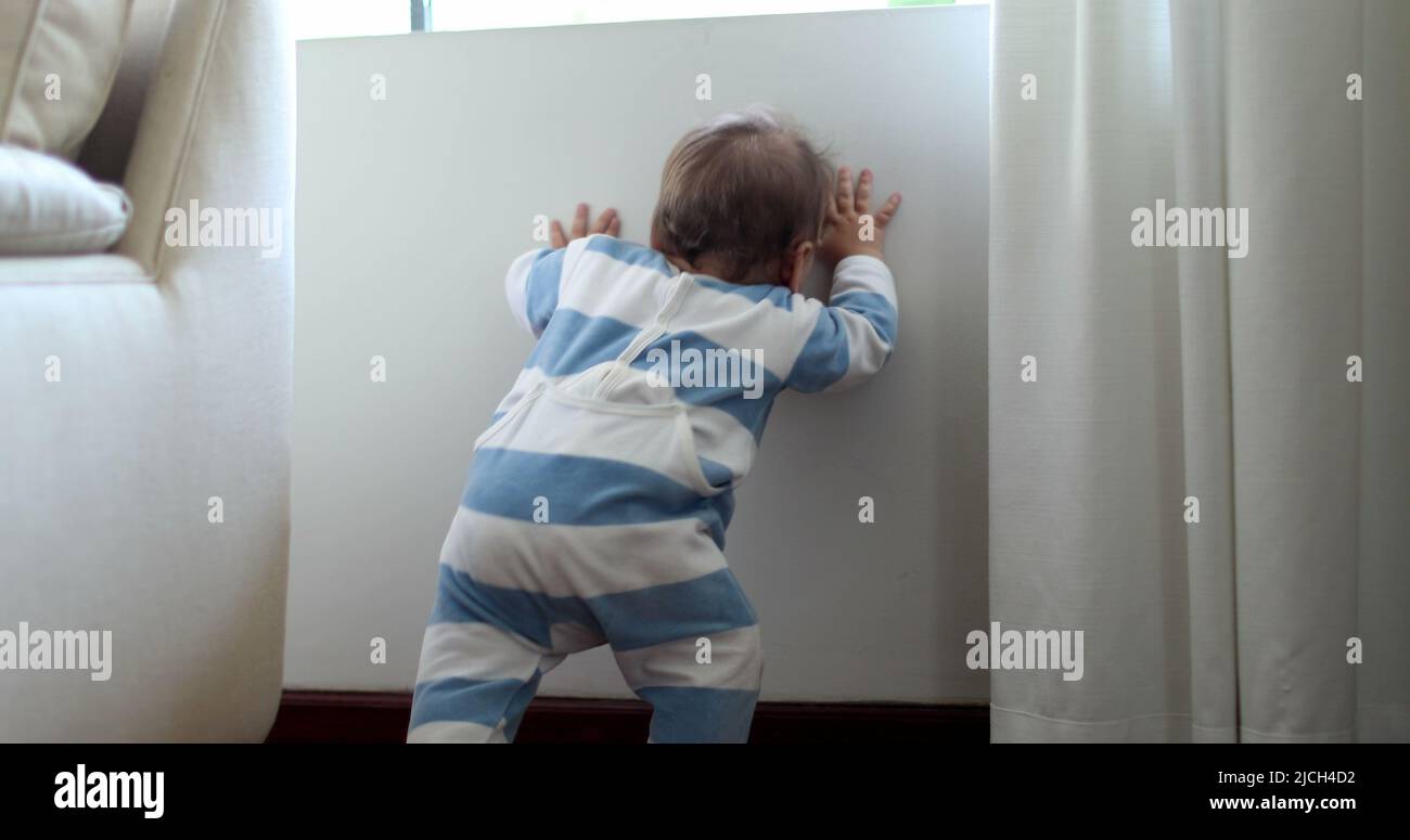 Cute baby boy standing up at home. Infant child learning development ...