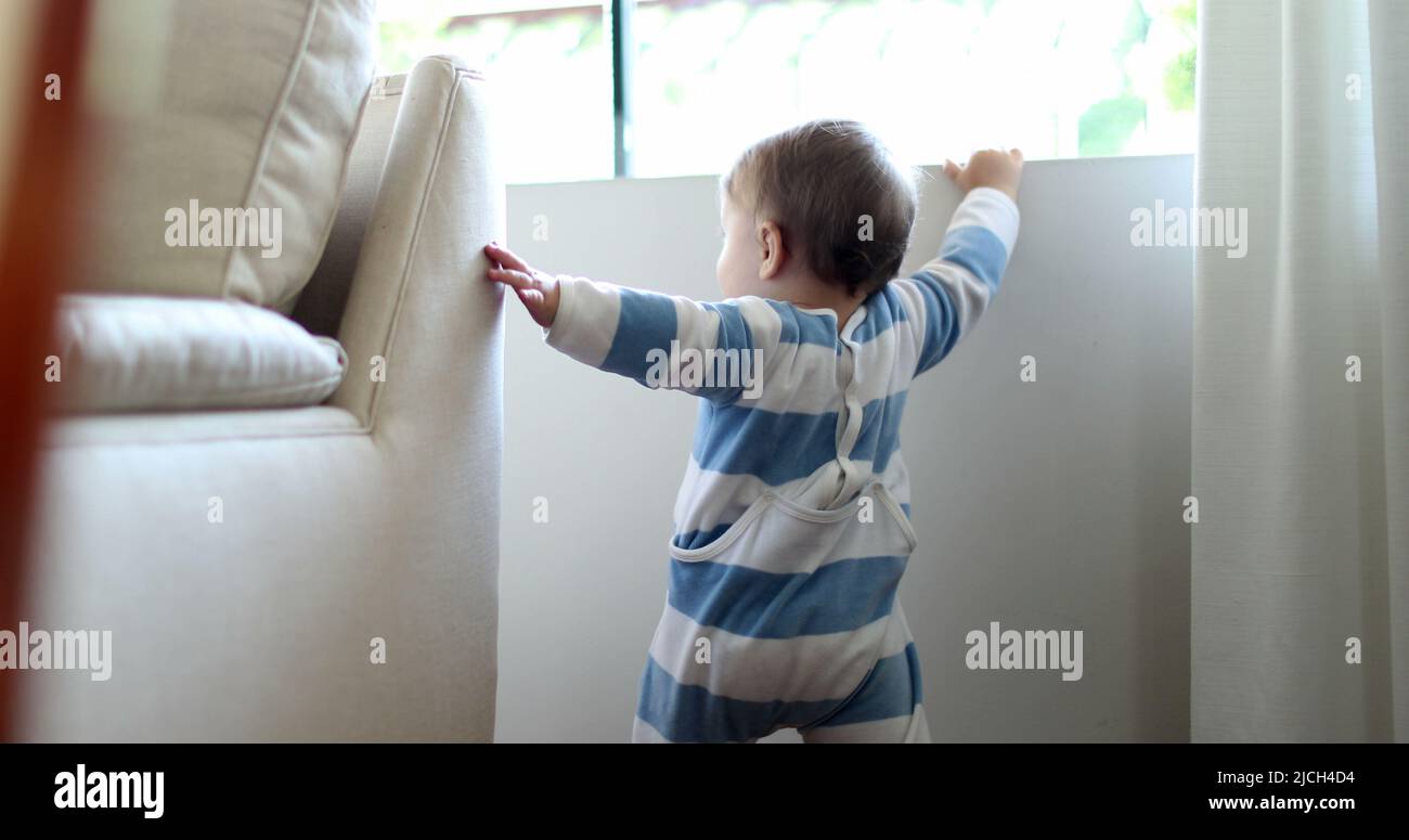 Cute baby boy standing up at home. Infant child learning development ...