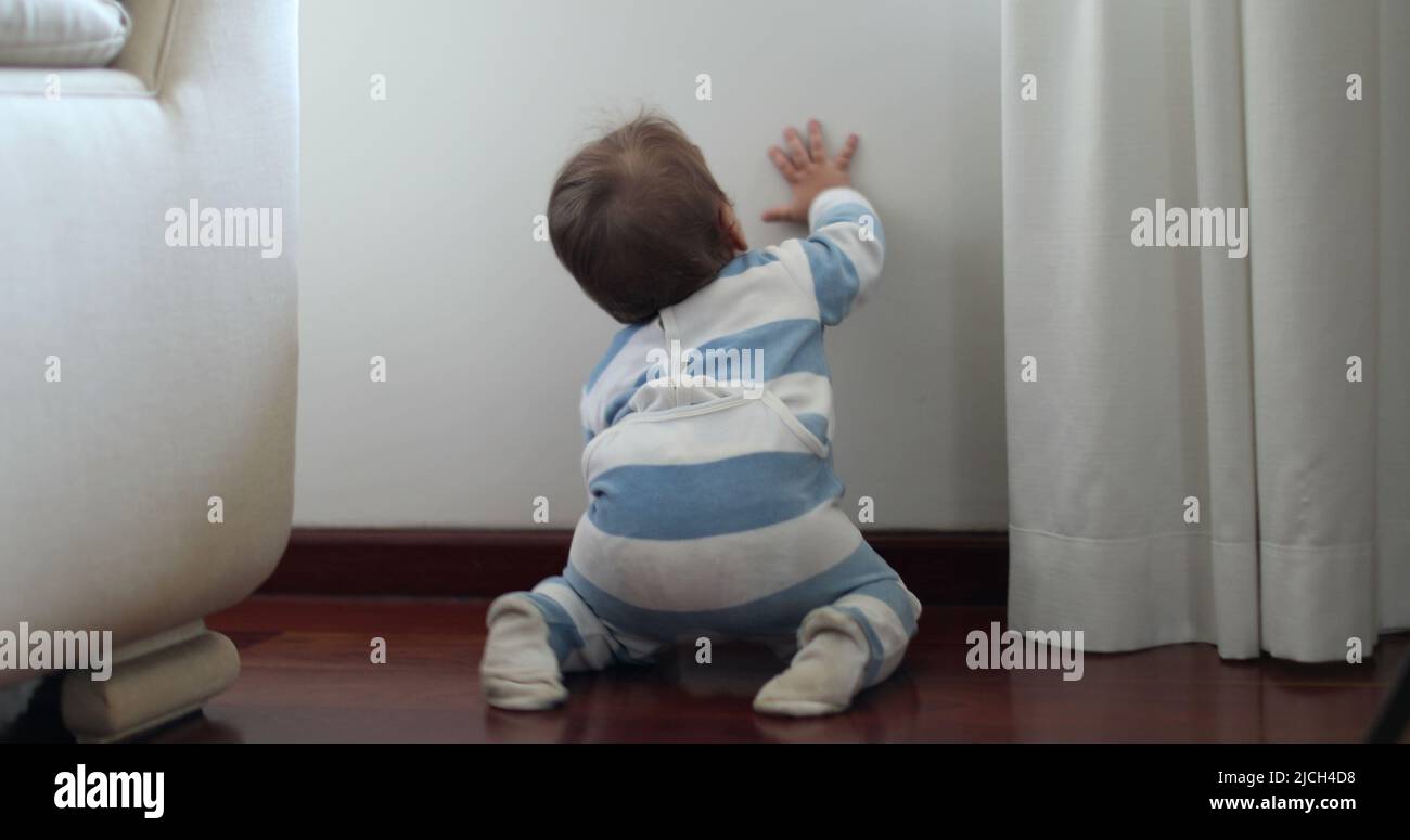 Cute baby boy standing up at home. Infant child learning development ...