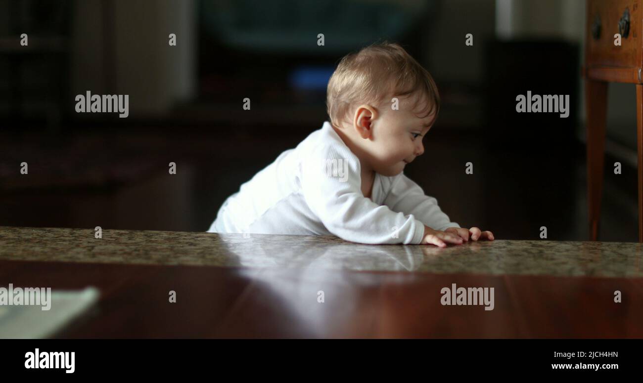 Cute baby learning to climb down home step, infant development Stock ...