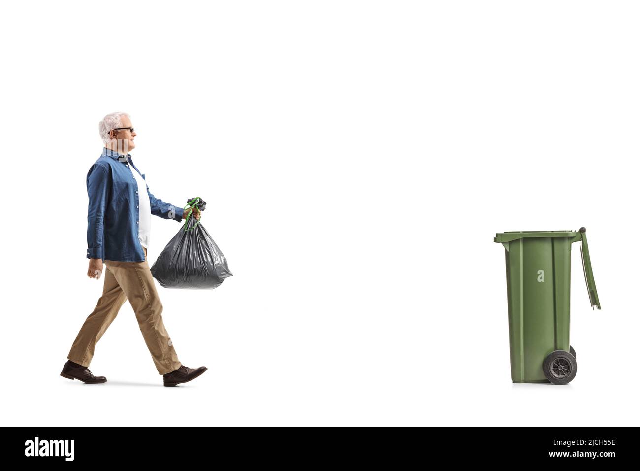 Full length profile shot of a mature man walking towards a dustbin and ...
