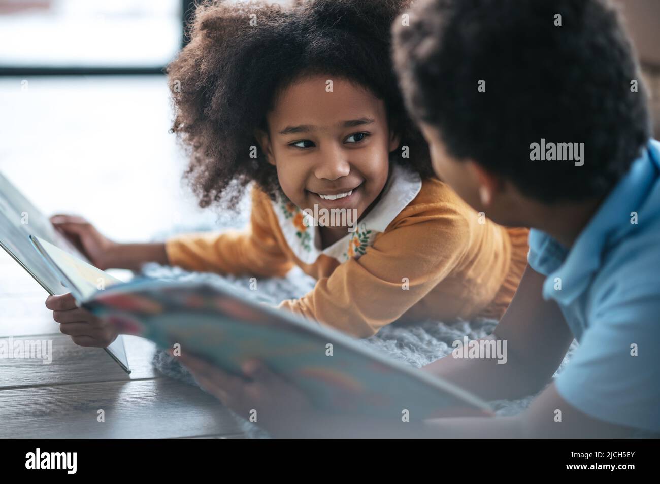 Two kids spending time together and reading Stock Photo - Alamy