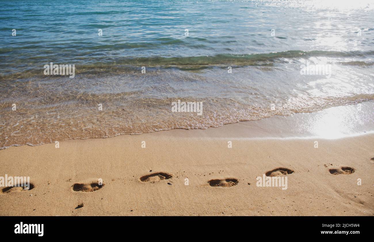 Footprints at golden sand, footsteps. Beach background. Calm beautiful ...