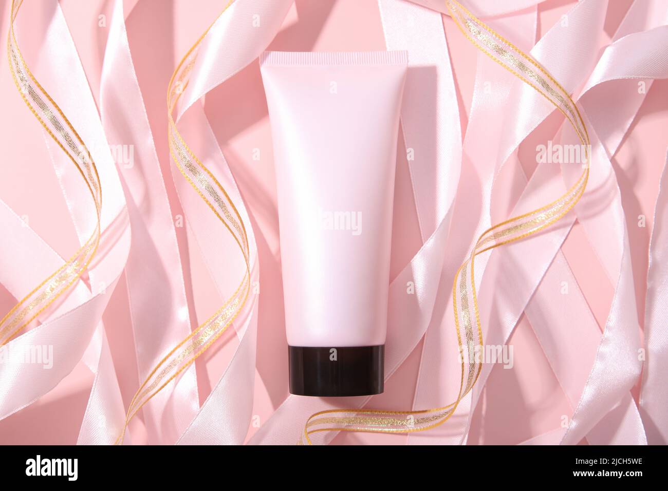 Pink squeeze bottle cosmetic tube with screw black cap and roll pink ...