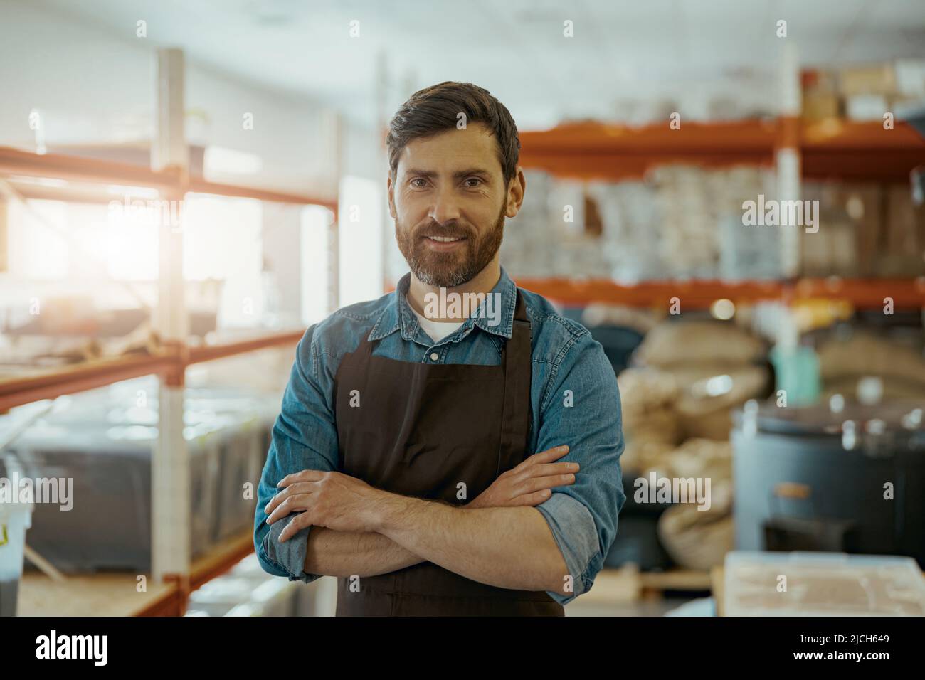 Portrait of smiling business owner on background of warehouse in small ...