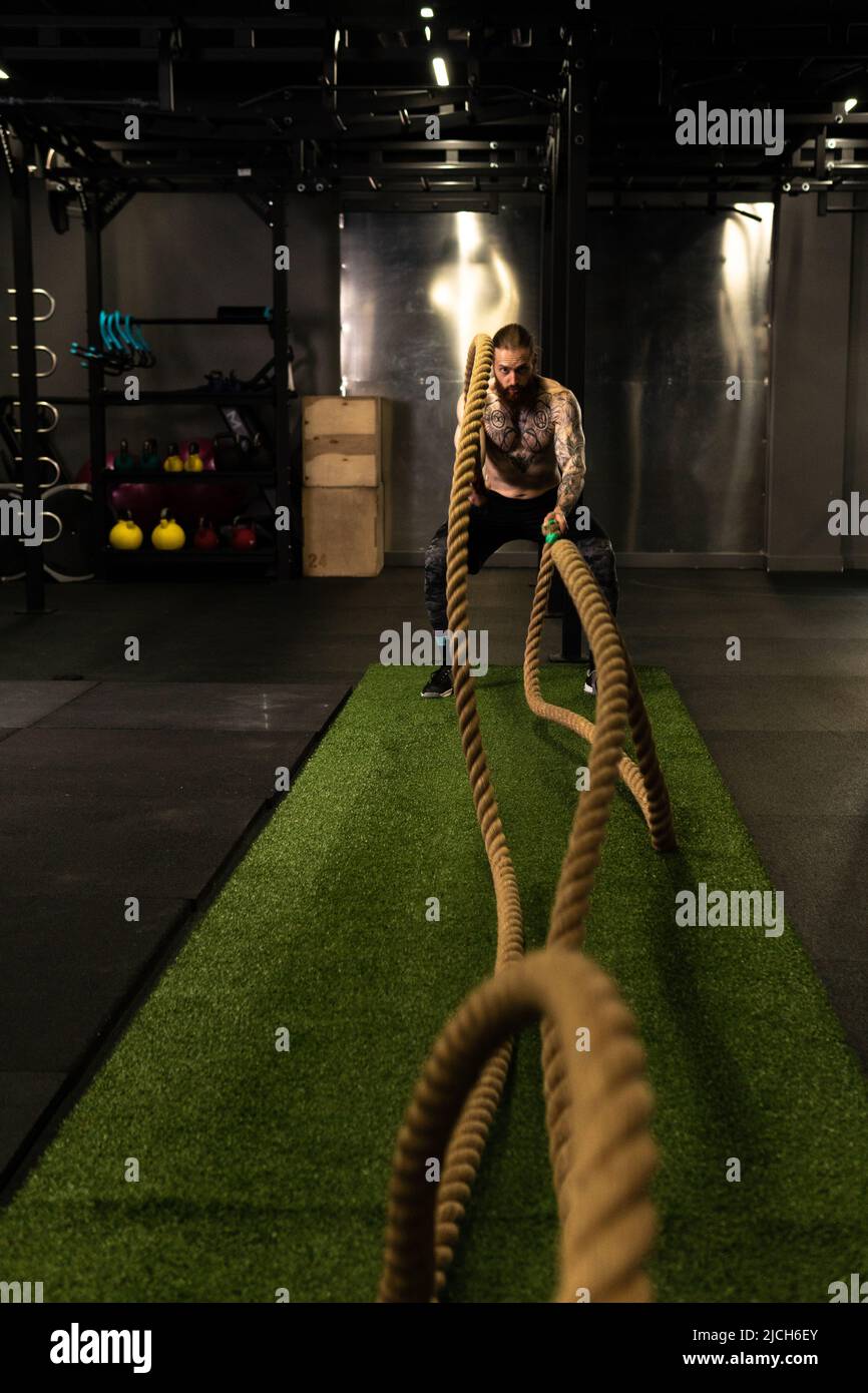 Rope training man warehouse fitness gym muscular exercising exercise ...