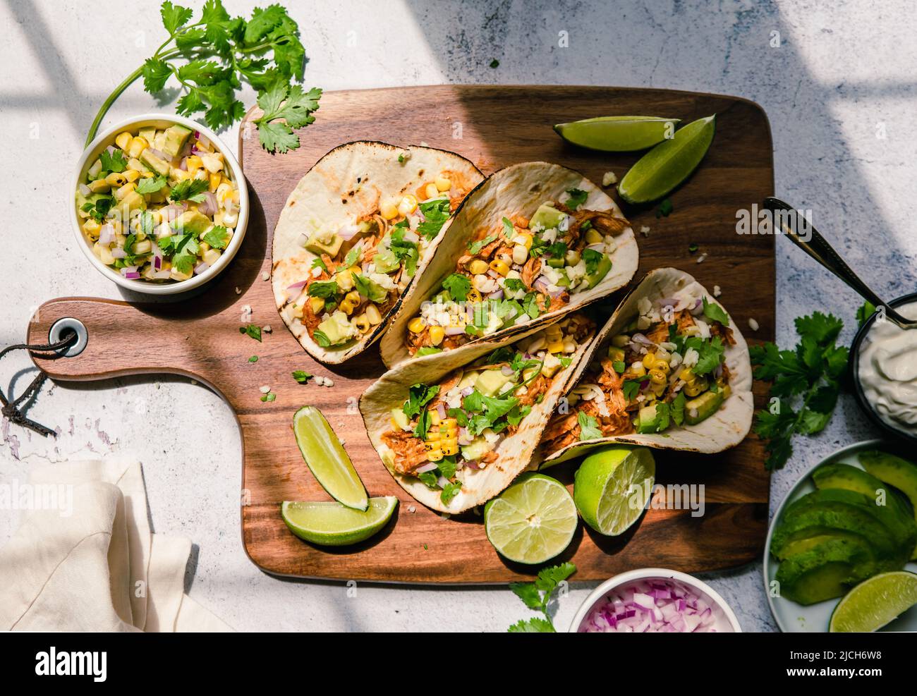 Overhead of soft tacos with chicken, corn, avocado and lime Stock Photo ...