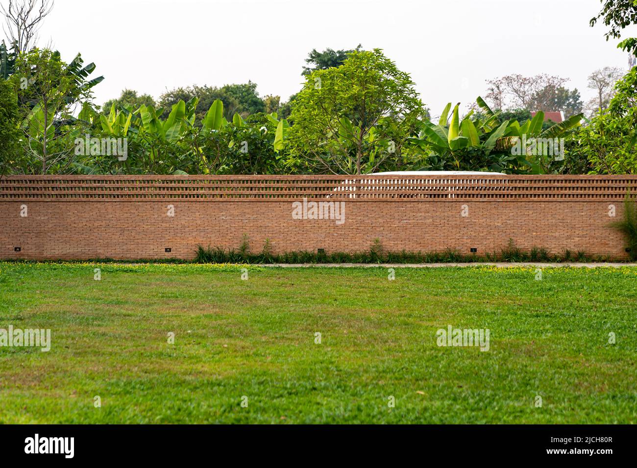 The brick wall, fence barrier is designed with a hole on top of wall in ...