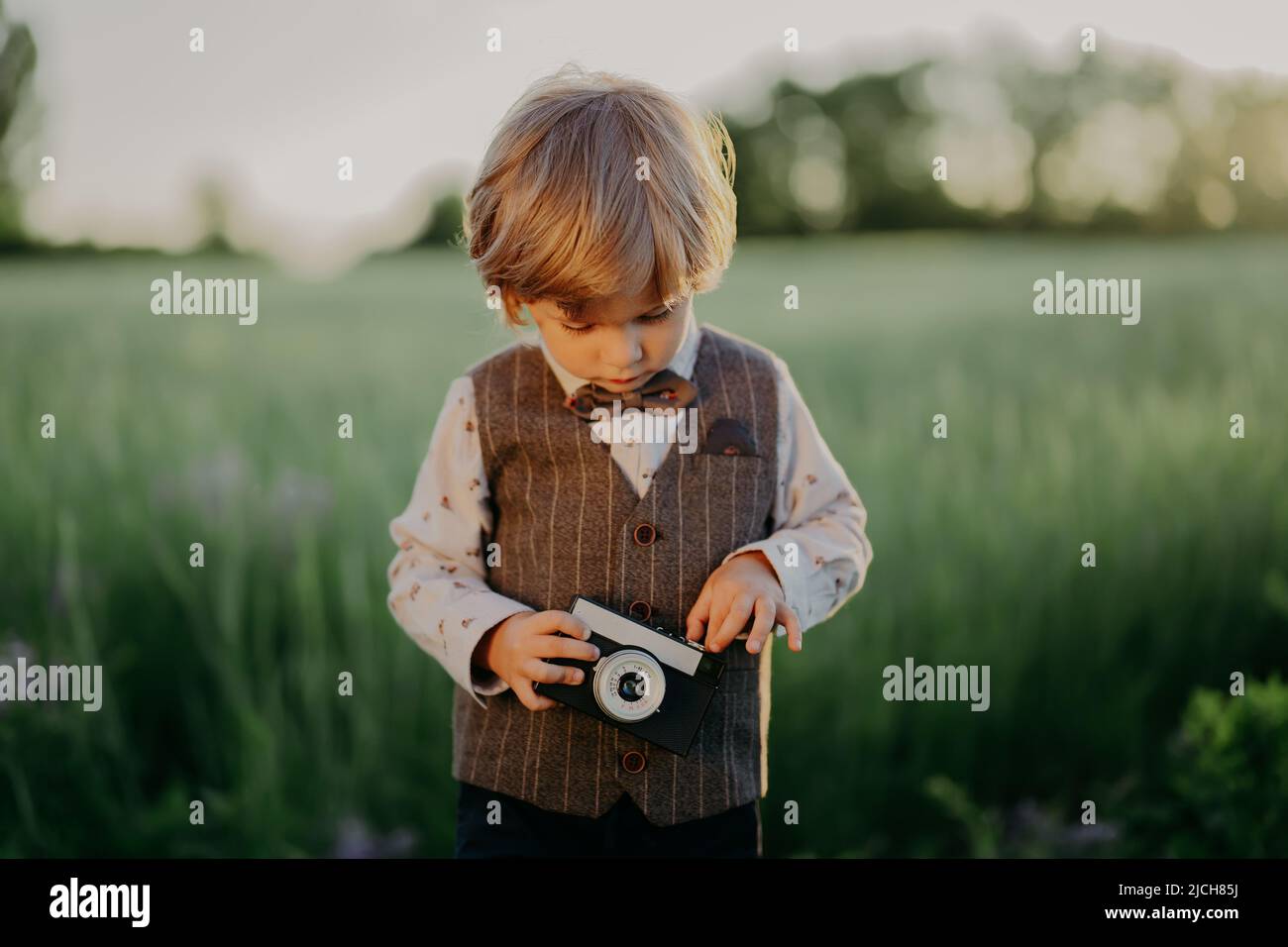 Hipster little boy with vintage camera outdoors. Child in costume Stock ...