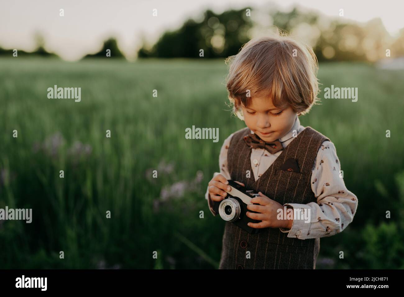 Hipster little boy with vintage camera outdoors. Child in costume Stock ...