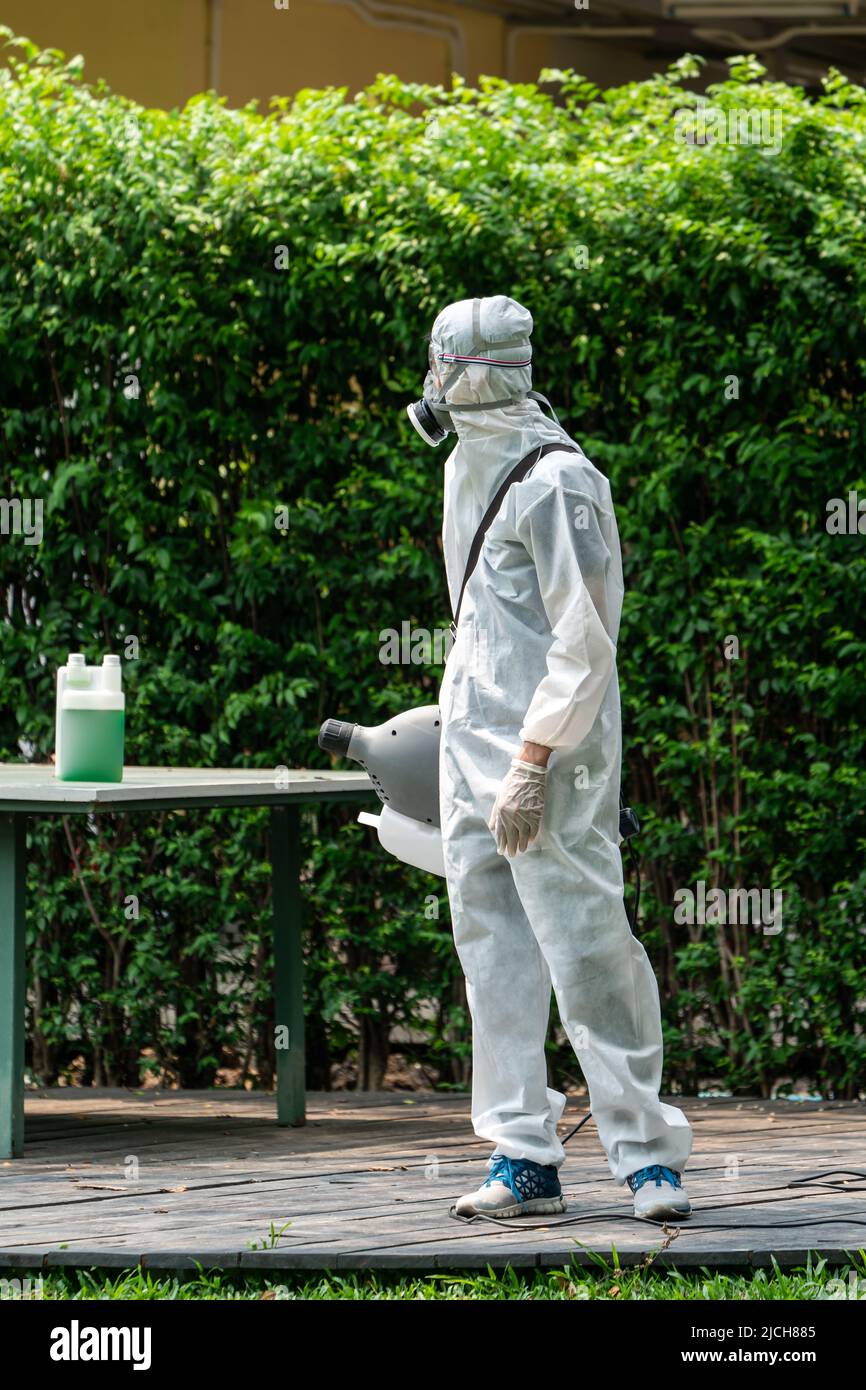 Professional technical man in prevention suit with his sterilizing machine and disinfecting ...