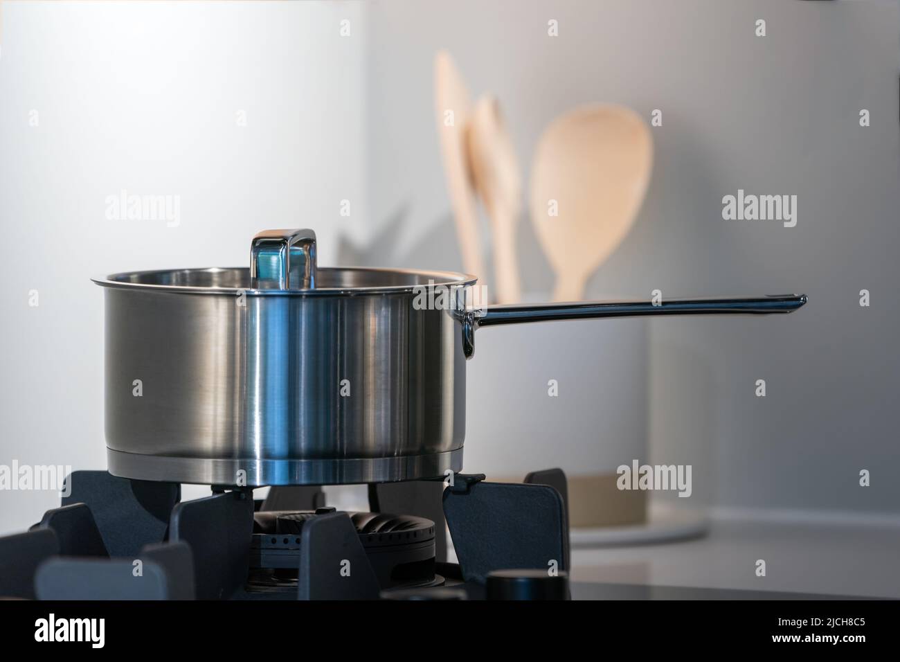 stainless steel pot on electronic modern flat stove in low light on ...
