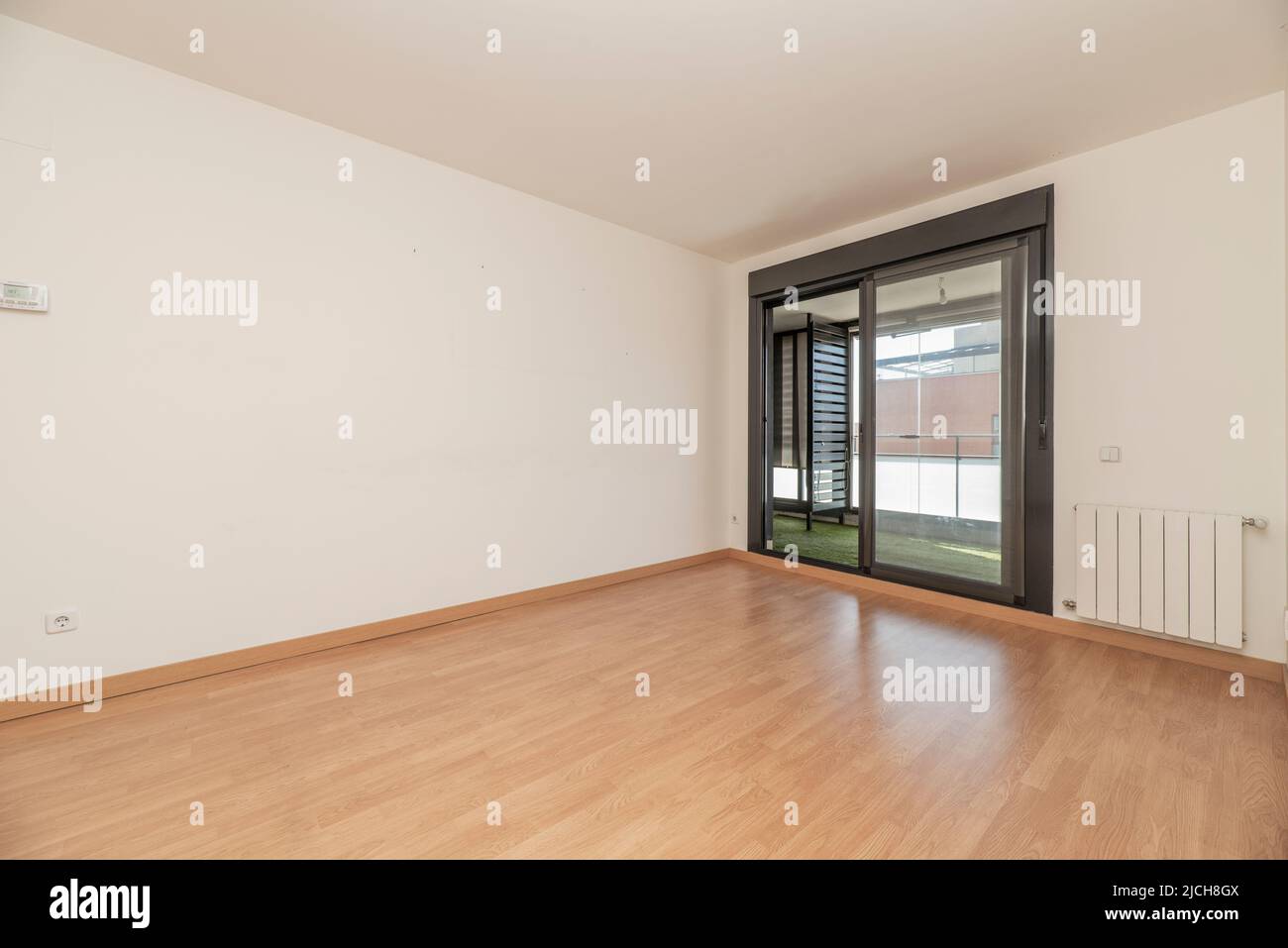 Empty living room with exit to a terrace with dark aluminum sliding ...