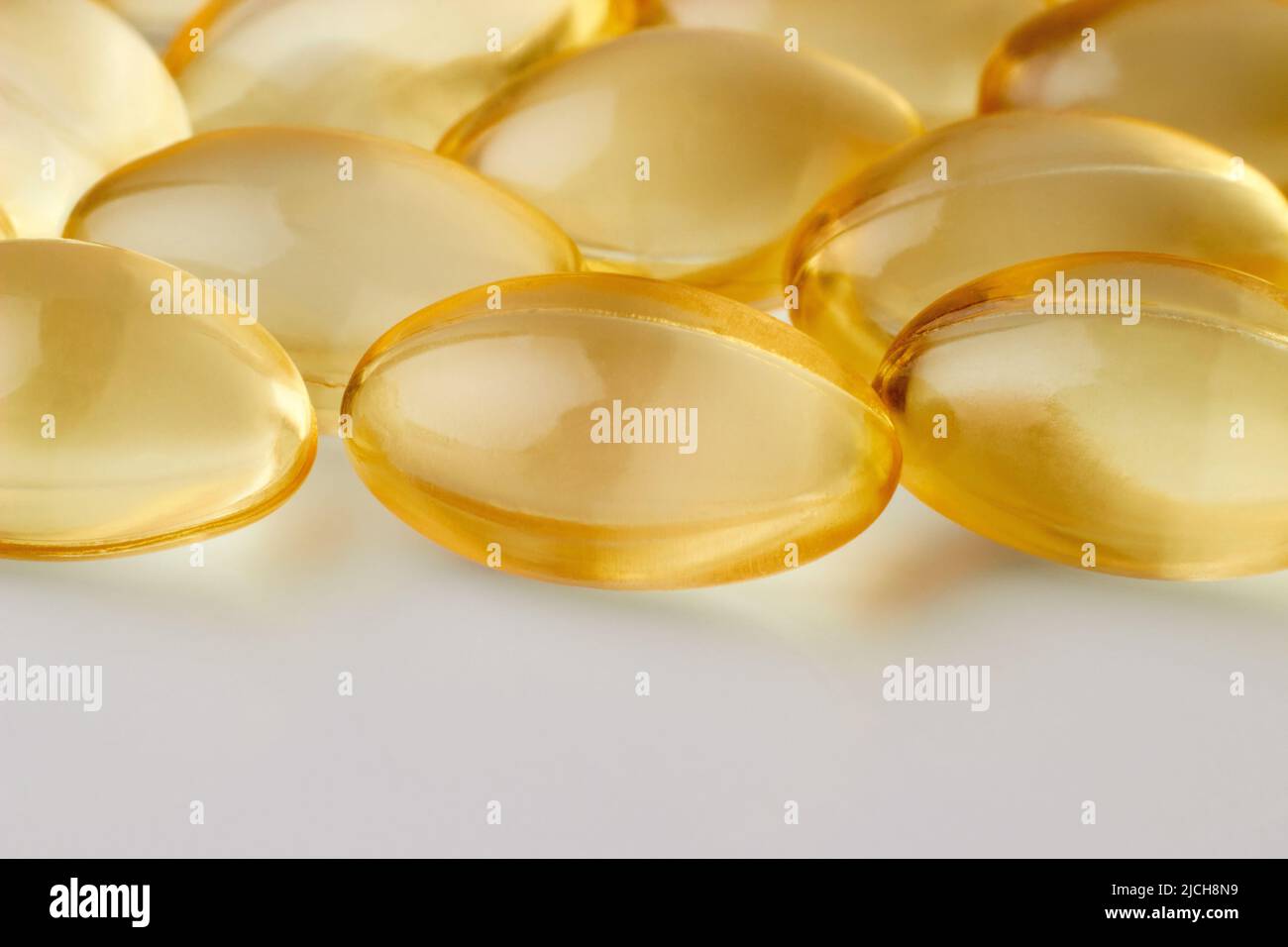 Vitamin D capsules in a close up on a light background. To support ...