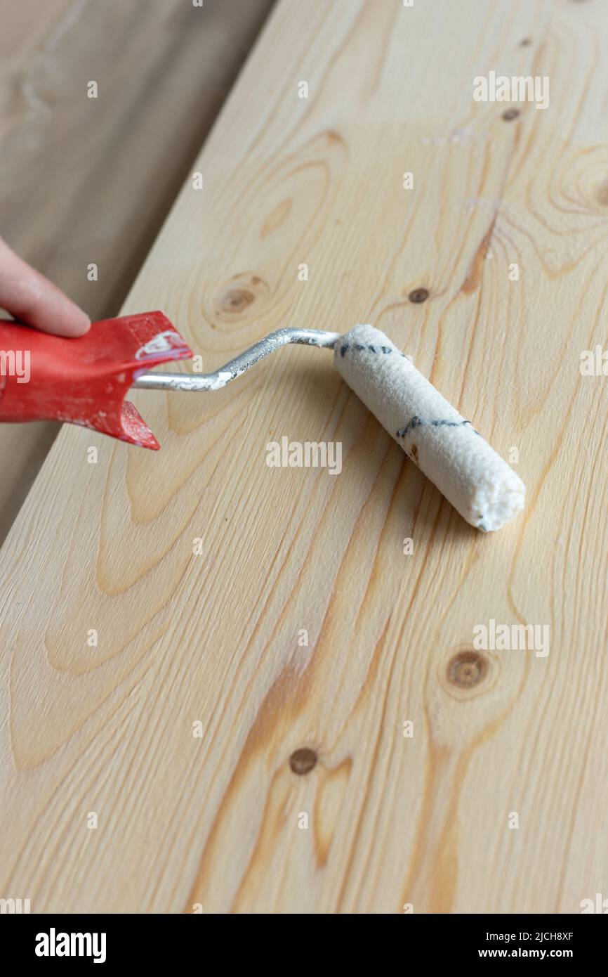 Coating the board with varnish using a roller Stock Photo - Alamy