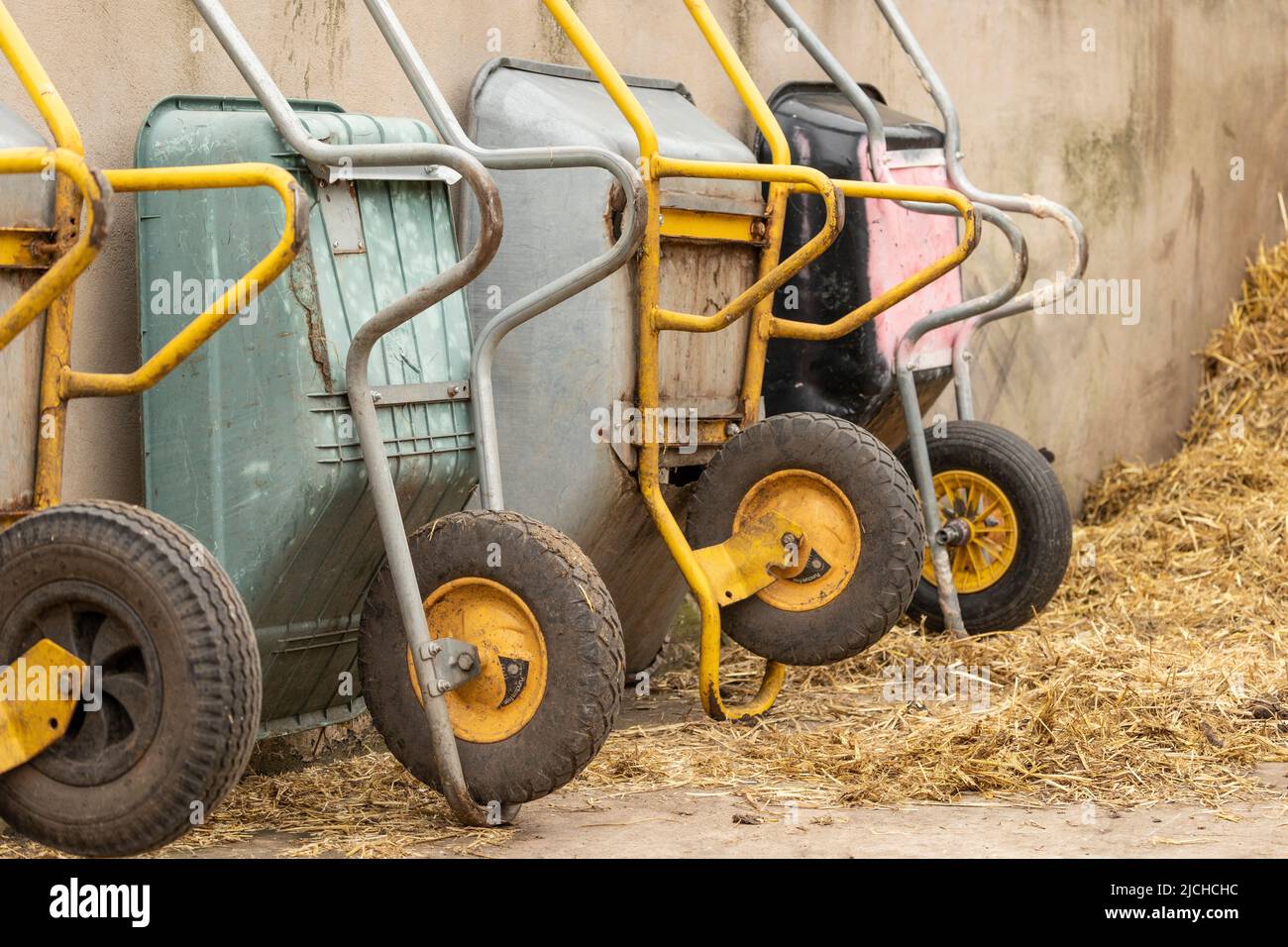 stacked upright farm wheel barrows Stock Photo - Alamy