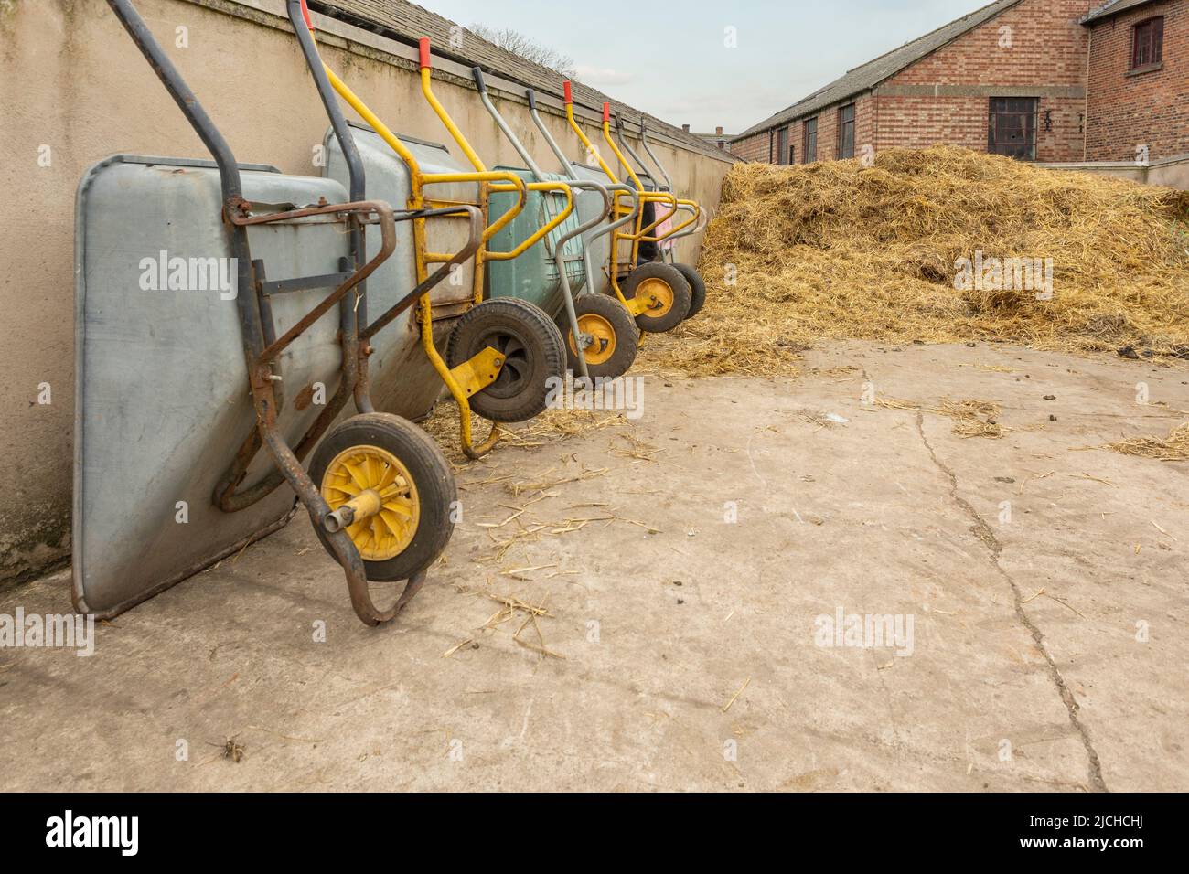 stacked upright farm wheel barrows Stock Photo - Alamy