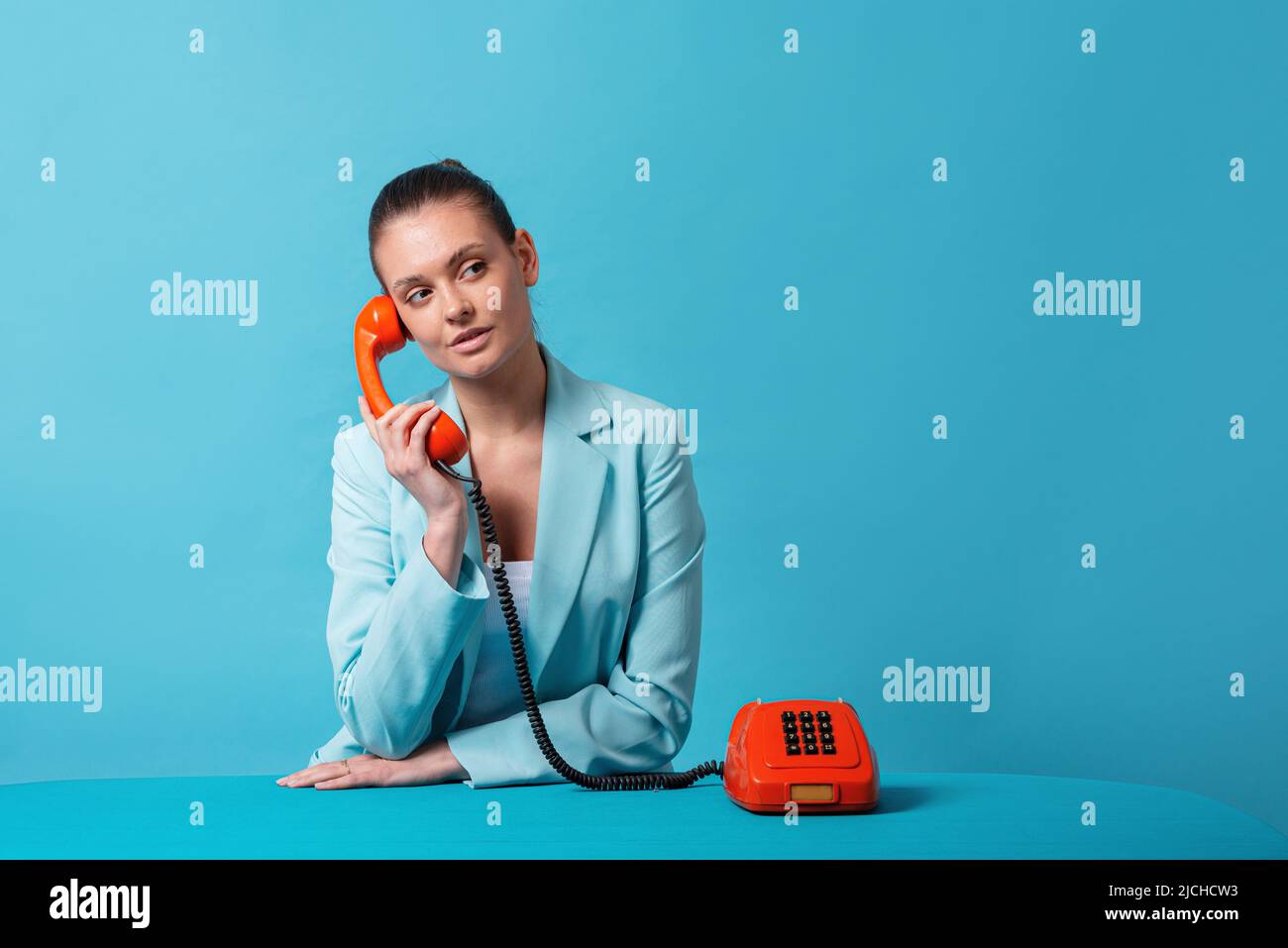 Woman talking over the phone over a blue background, concept, smiling ...