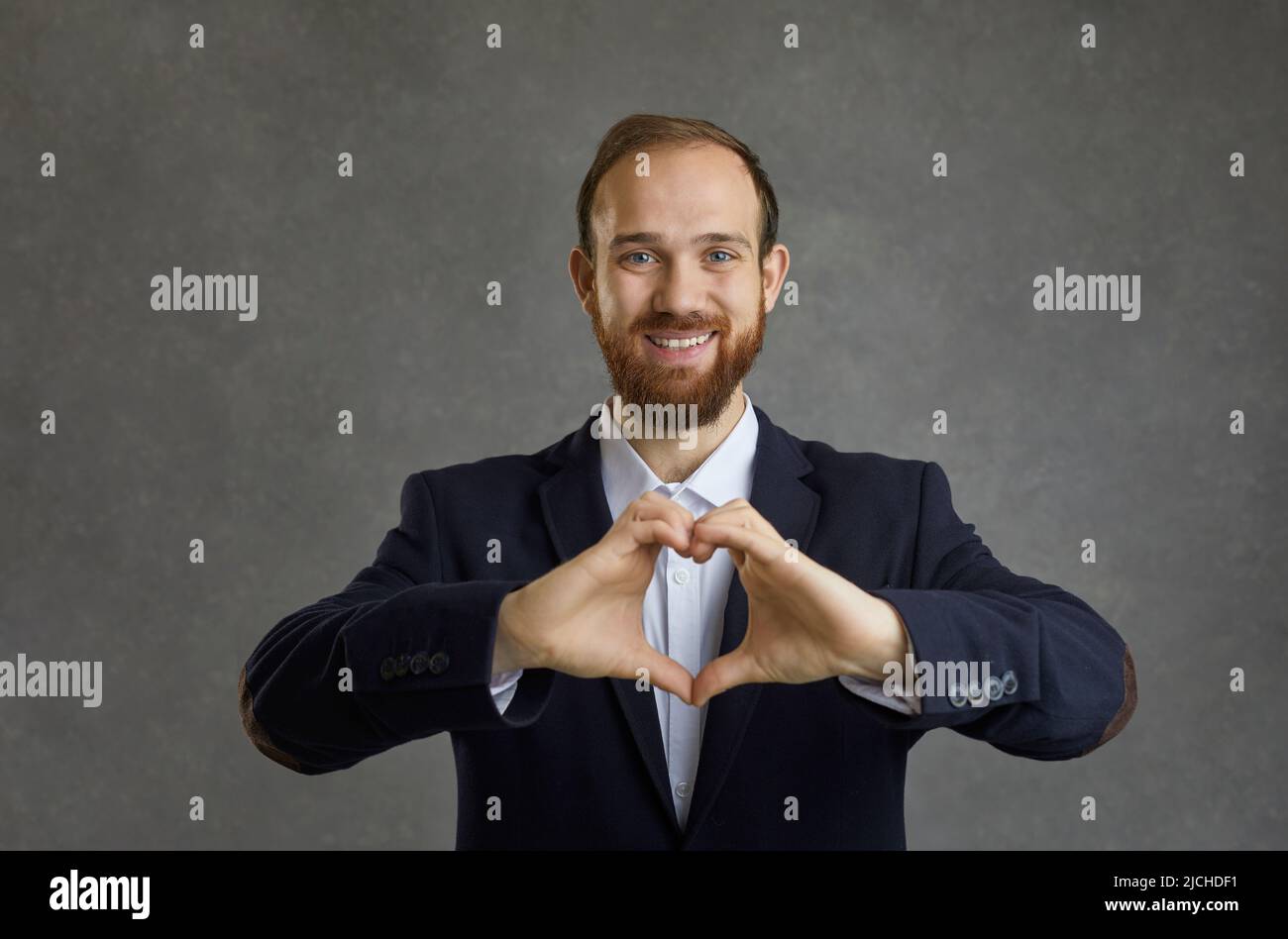 Middle aged handsome businessman in suit smiling showing heart shape as ...
