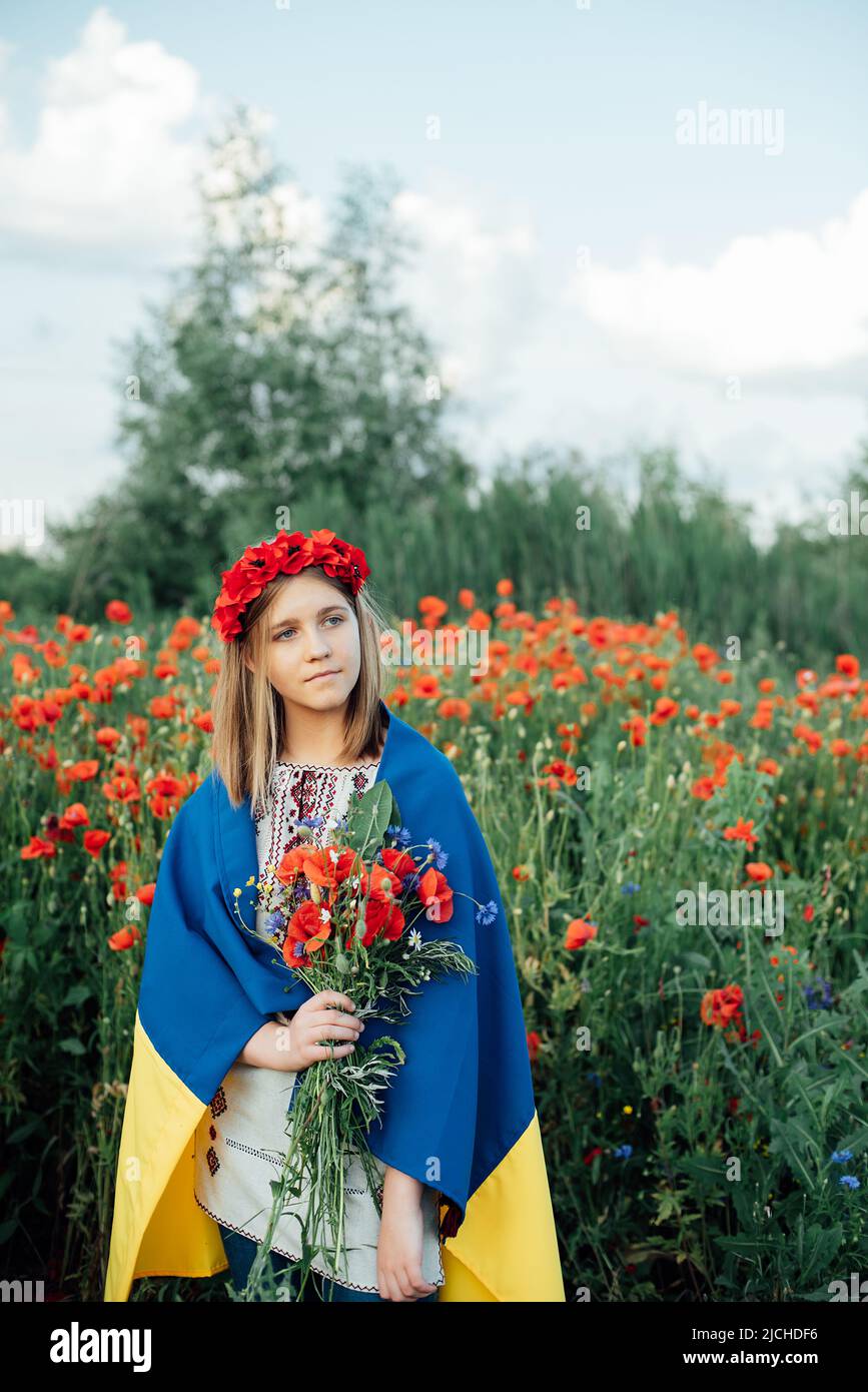 Girl carries fluttering blue and yellow flag of Ukraine in field ...