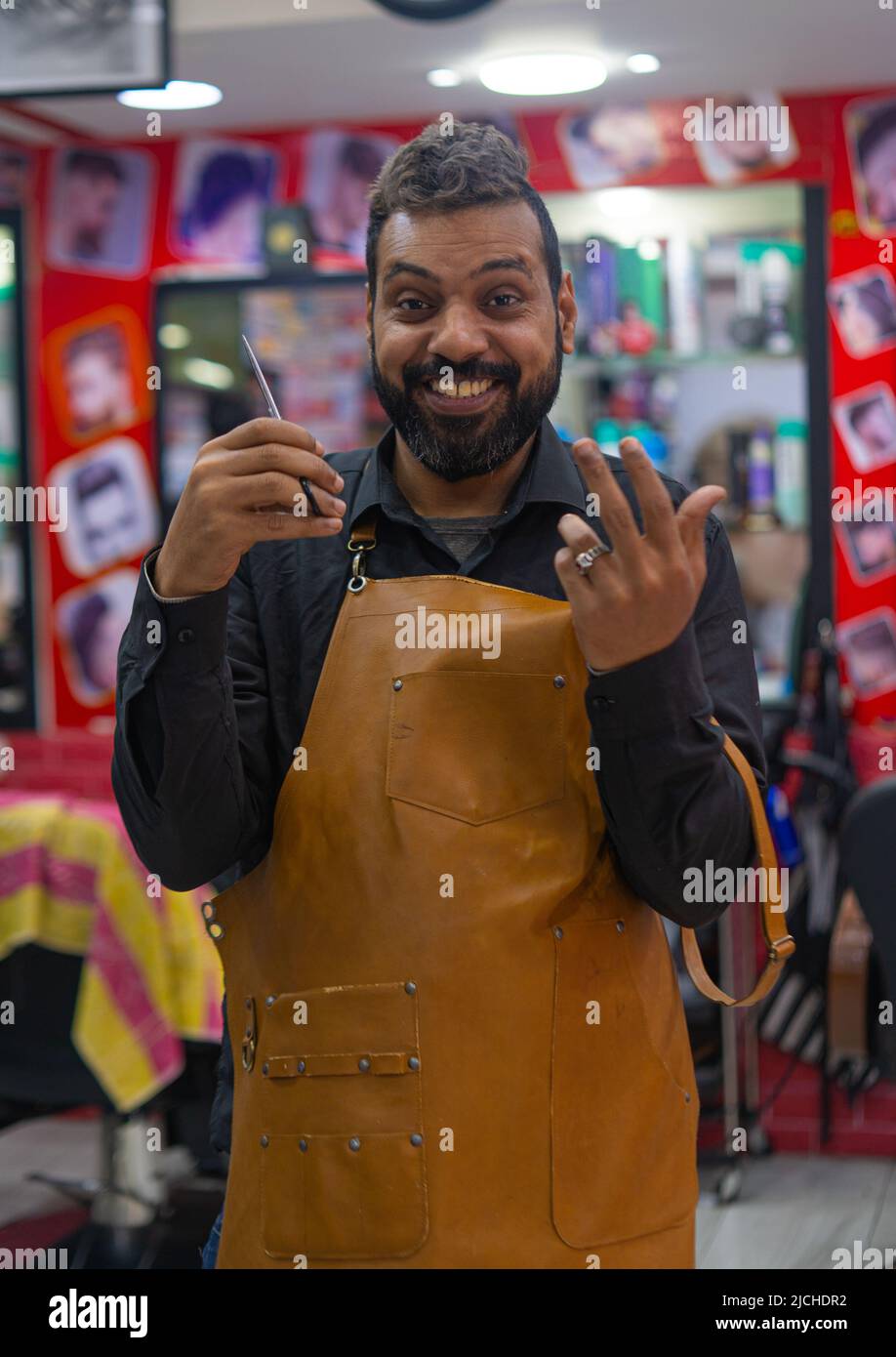 Happy barber arab man portrait with scissors Stock Photo - Alamy
