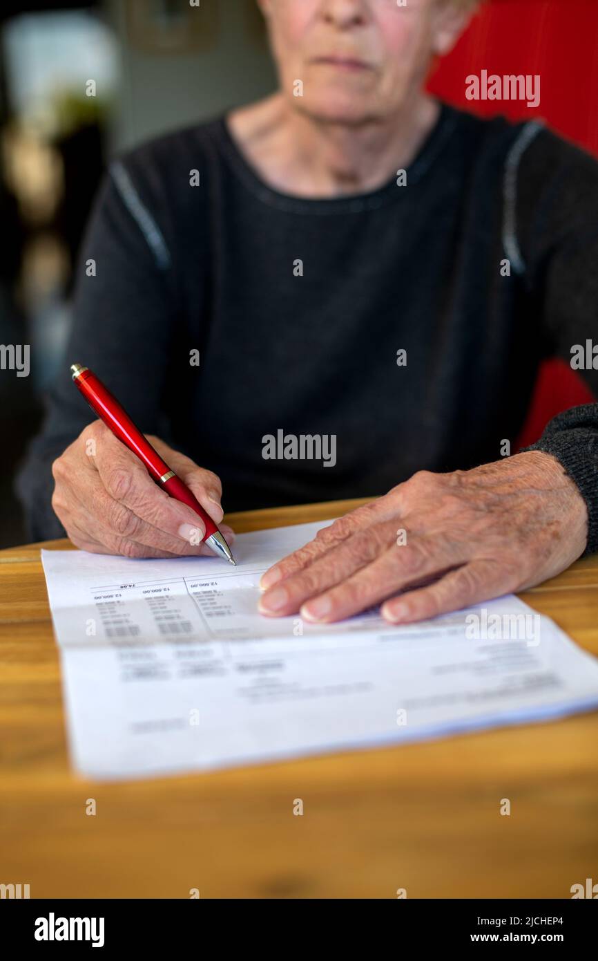 close-up of an older womans hand signing a paper Stock Photo - Alamy