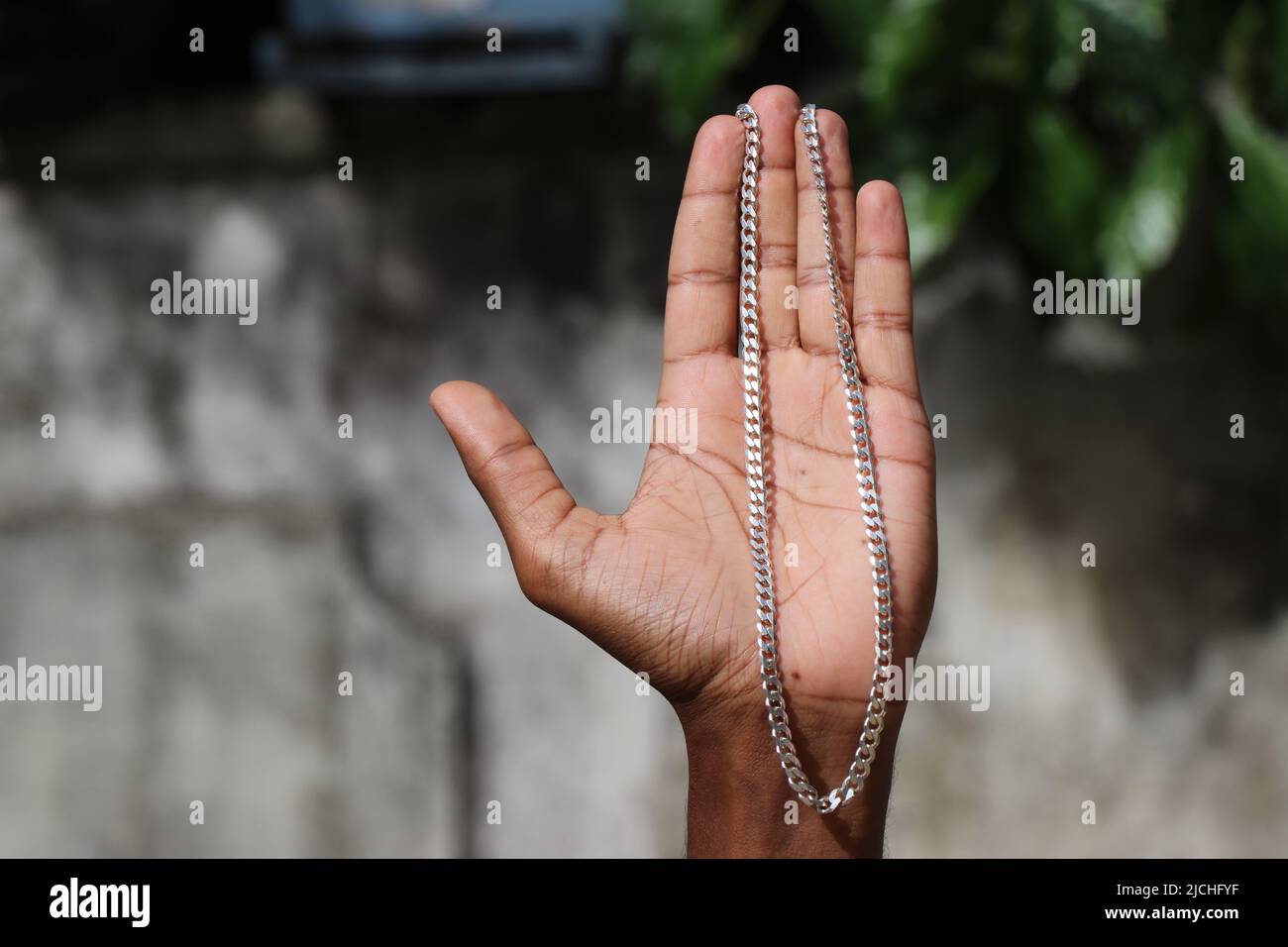 Pure silver chain that can be worn as a necklace held in hand against a ...