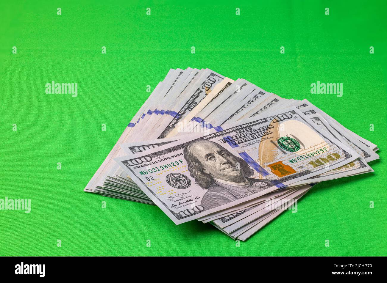 Macro view of spread out stack of dollars isolated on green background ...