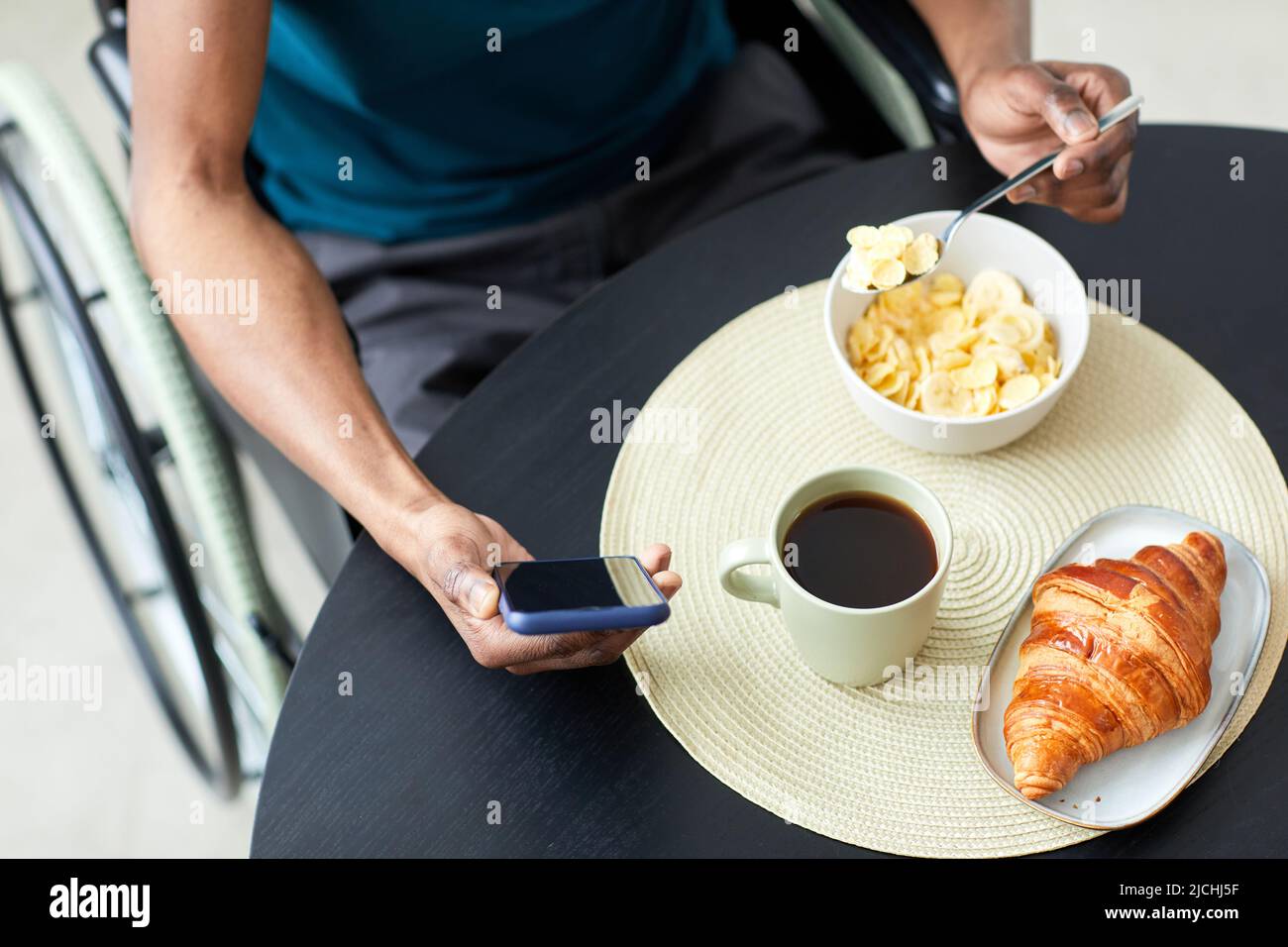 Top view of unrecognizable man with disability eating breakfast at home ...